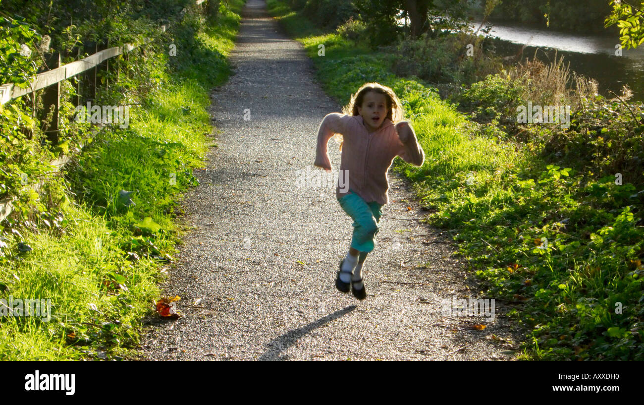 girl child running along riverside path Stock Photo - Alamy