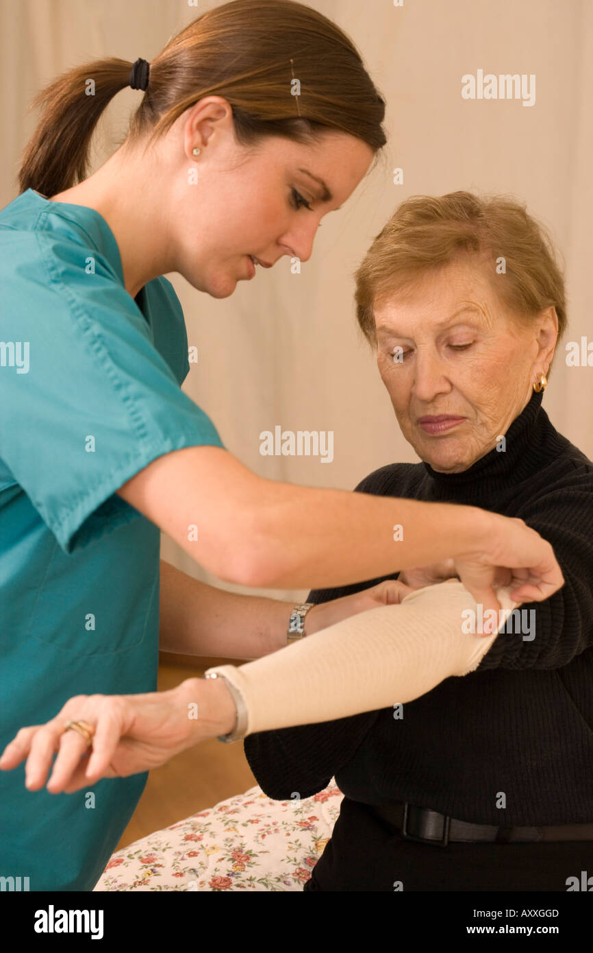 Nurse places (or changes) a bandage on patient's arm Stock Photo - Alamy