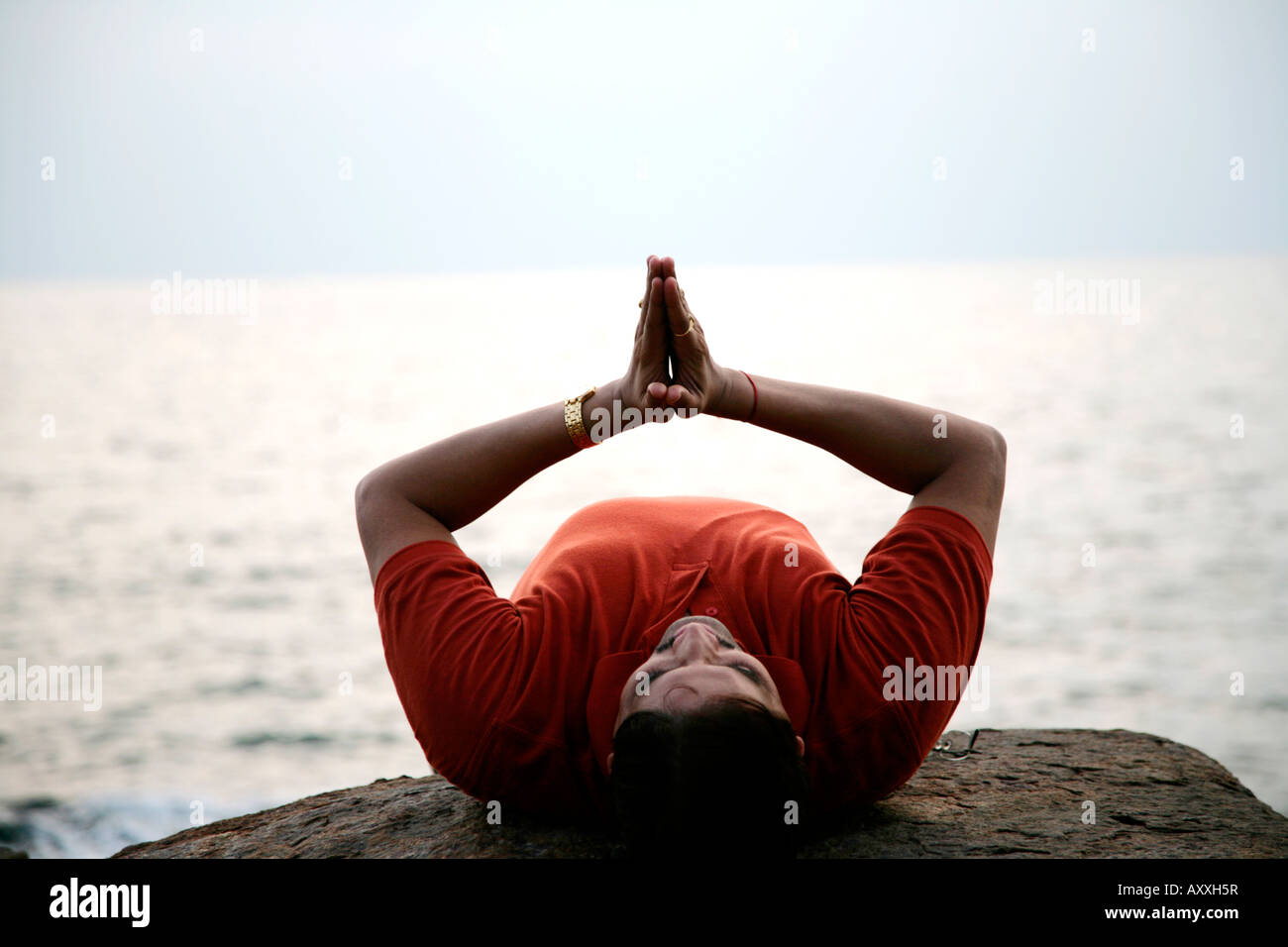 A man doing yoga at kovalam beach during sunset Stock Photo - Alamy