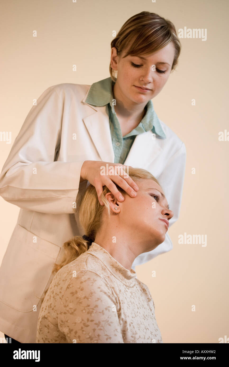 Female chiropractor adjusts the head, neck and spine of female patient ...