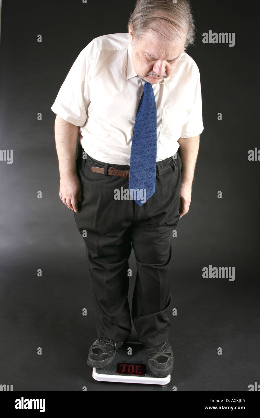Overweight man stands on scale to check his weight Stock Photo - Alamy