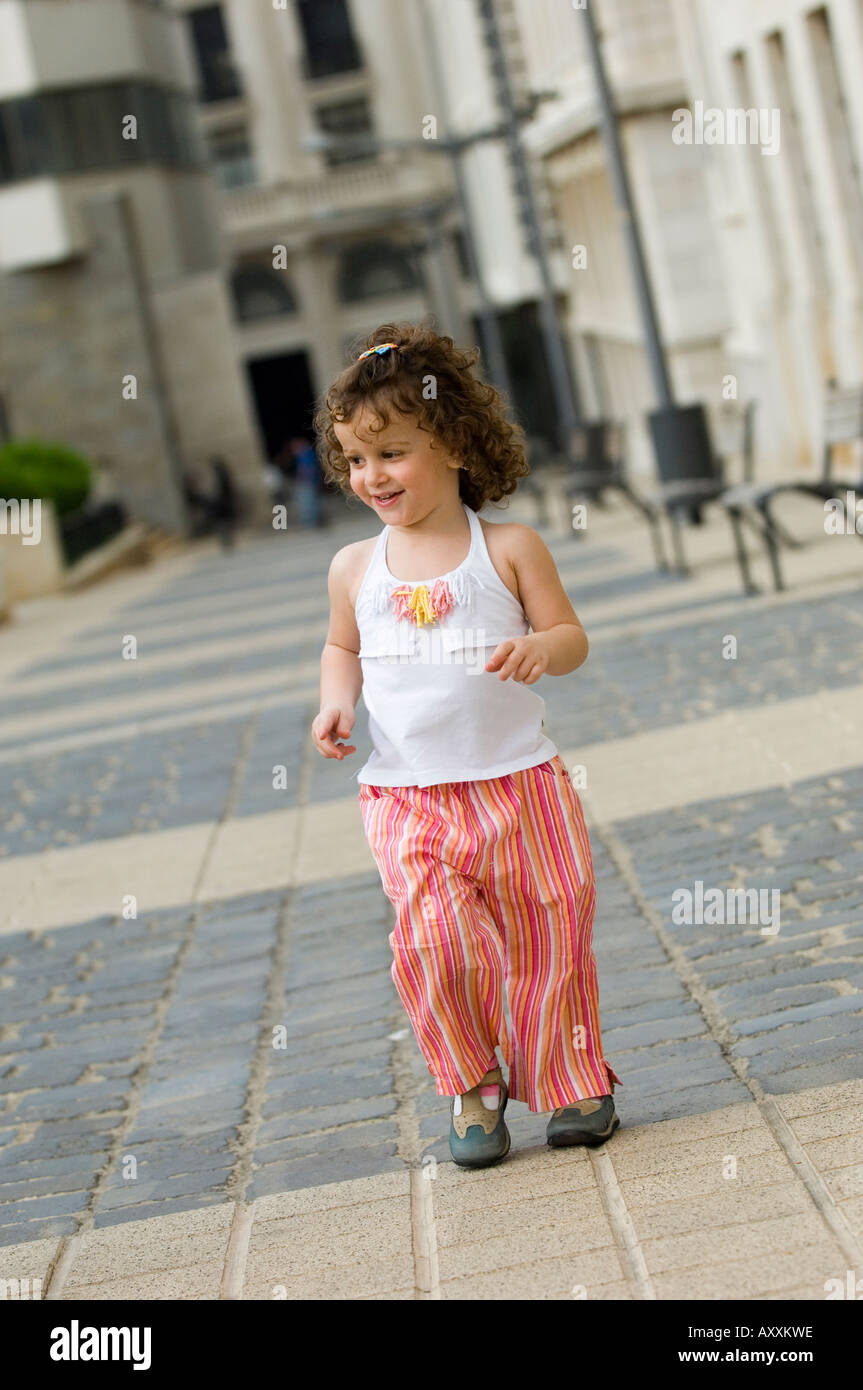 Little girl walking in the street Stock Photo - Alamy
