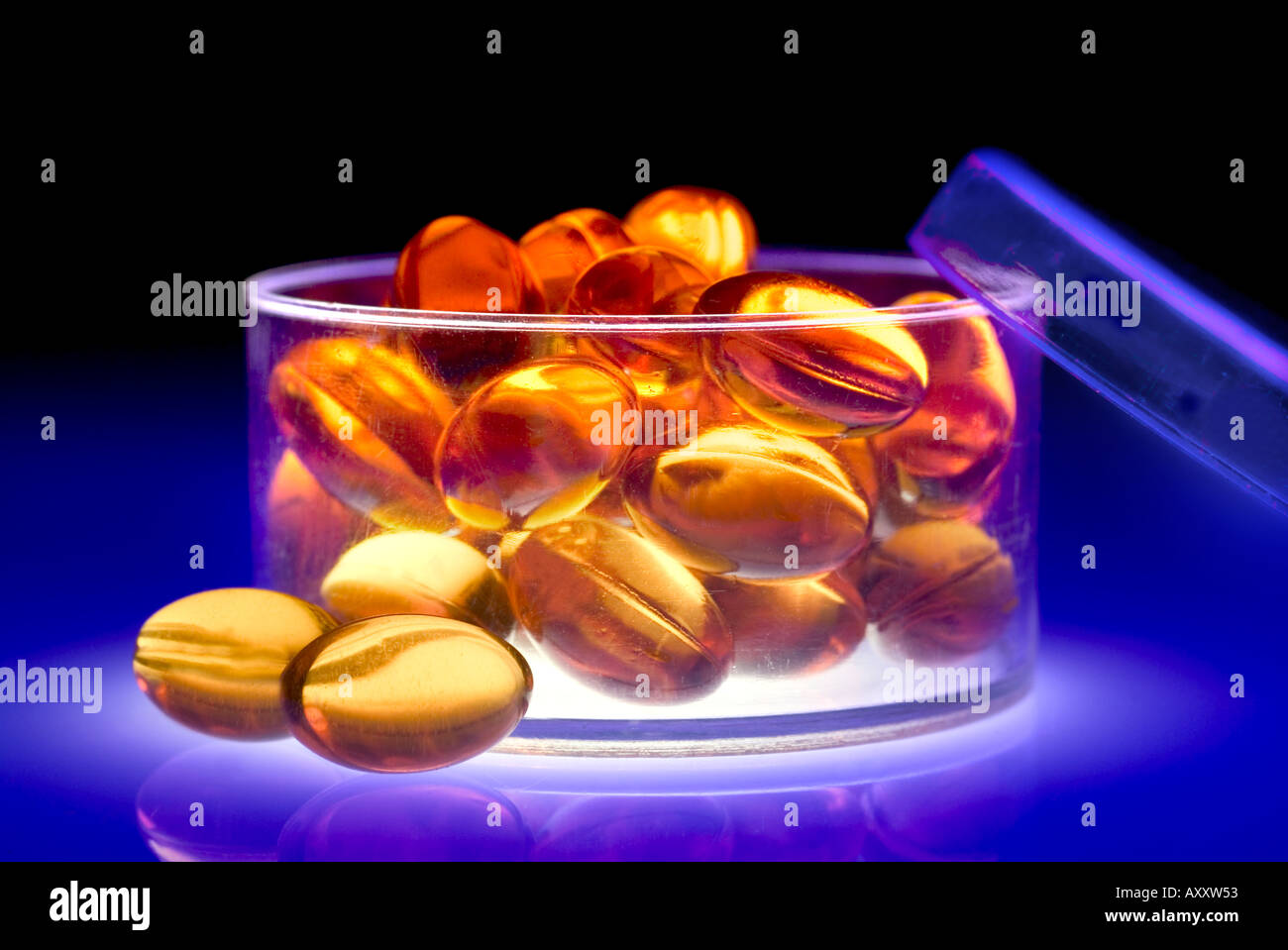 Amber gel caps in clear container close up Stock Photo - Alamy