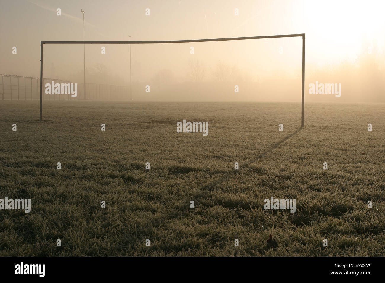 Football goal posts on a frozen pitch on a misty foggy field on a ...