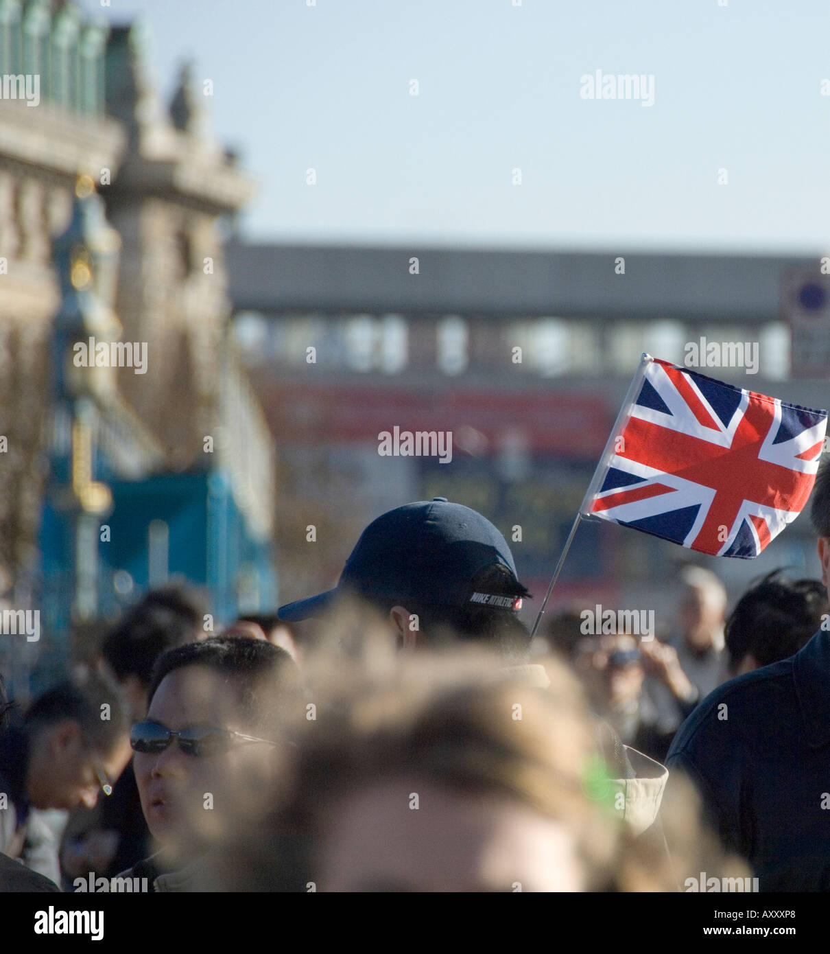 A tour guide in central London waving a Union Jack flag to attract his ...
