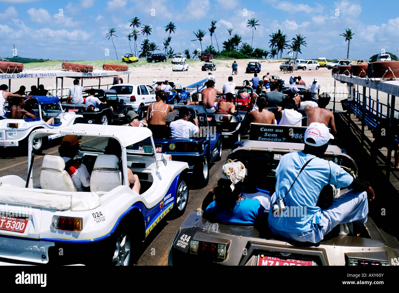 Dozens of beach-buggies are ferried across a lagoon on their way to the ...