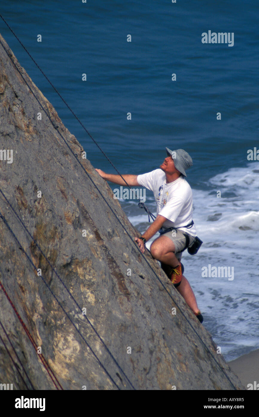 Rock climber climb cliff over ocean water waves at Point Dume State ...