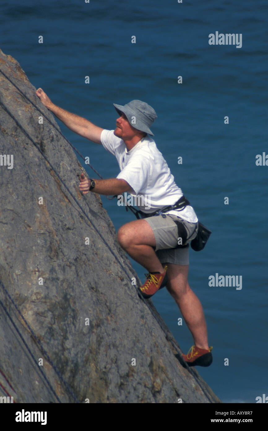 Rock climber climb cliff over ocean water waves at Point Dume State ...