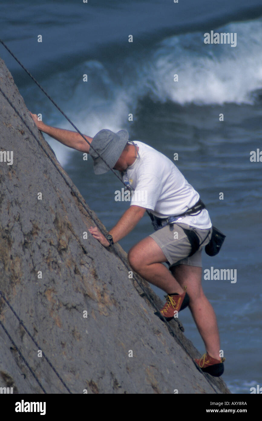 Rock climber climb cliff over ocean water waves at Point Dume State ...