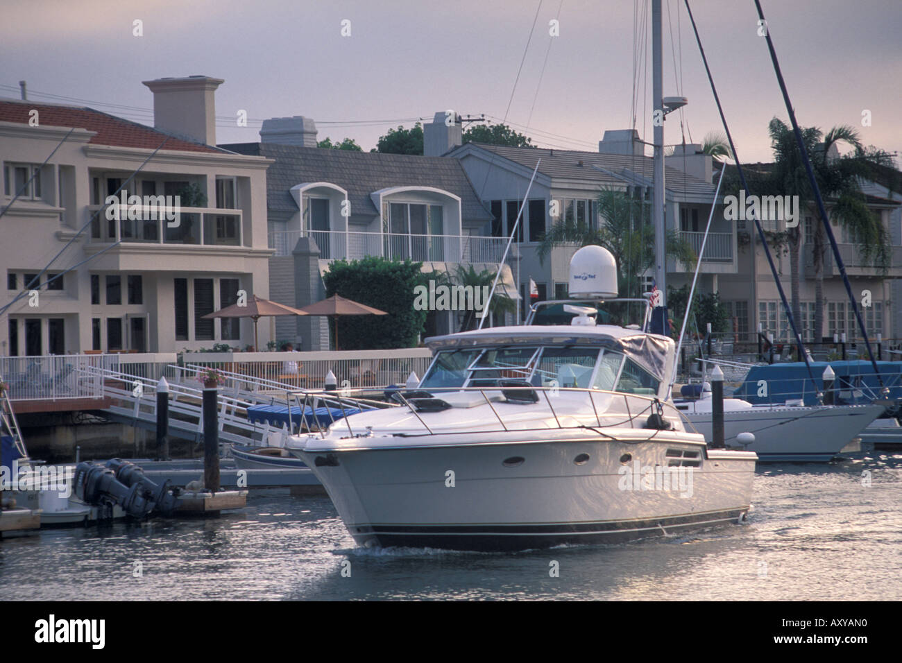 Luxury yacht Boat cruising through harbor channel next to waterfront ...