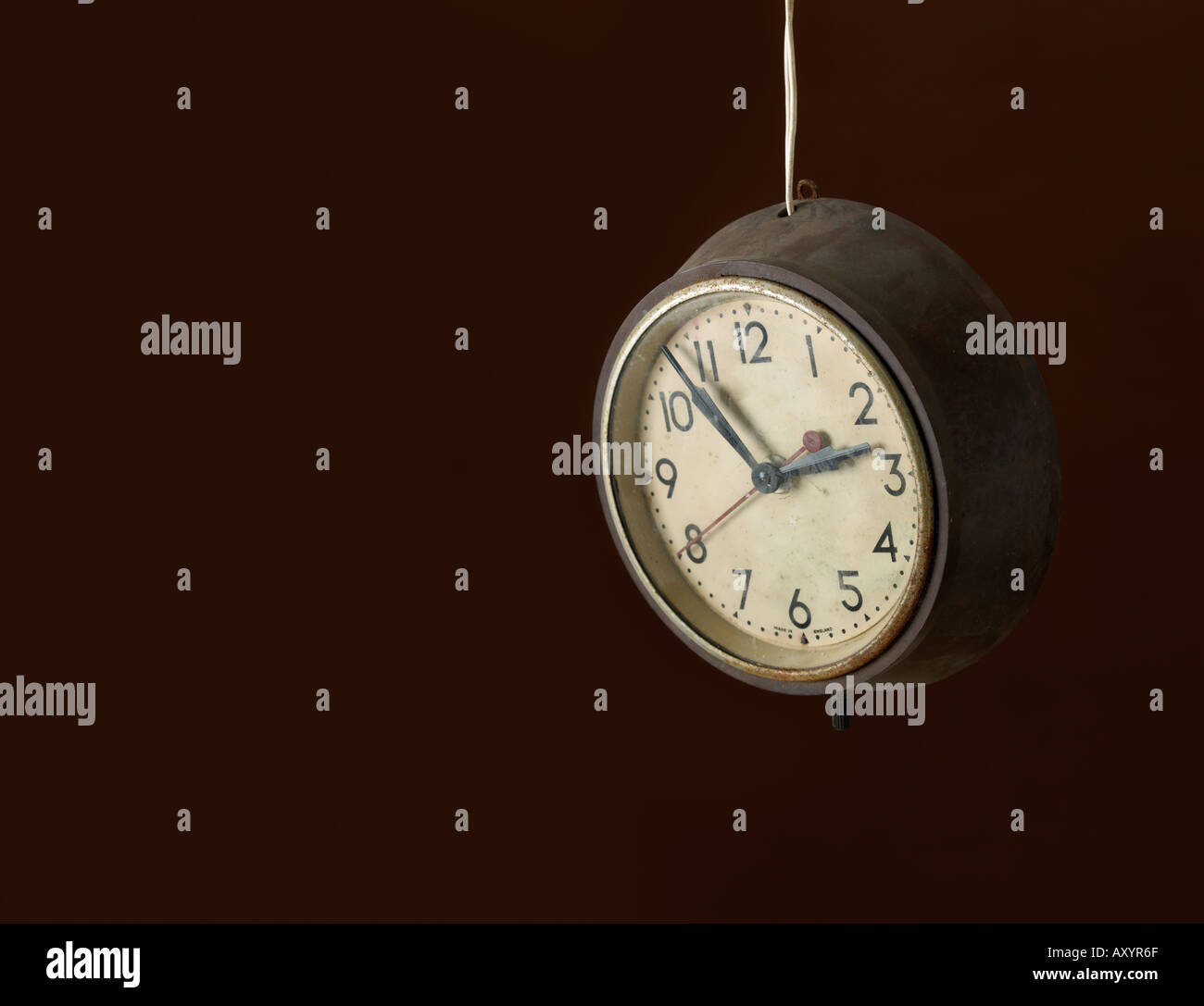 An old clock hanging by its cable Stock Photo - Alamy