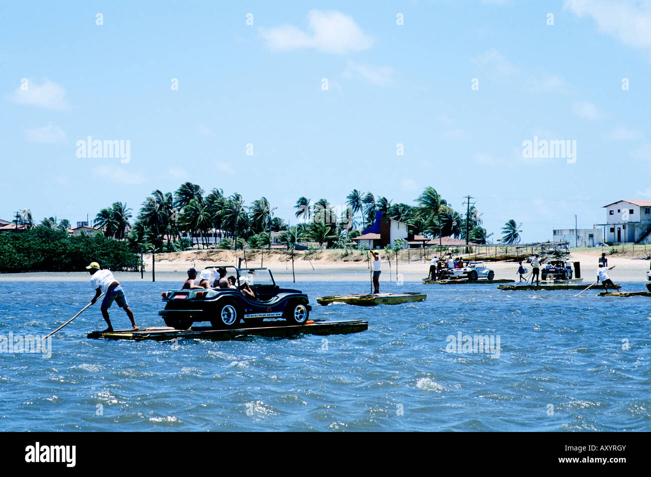 A single beach-buggy is punted across a shallow lagoon on a jangada ...