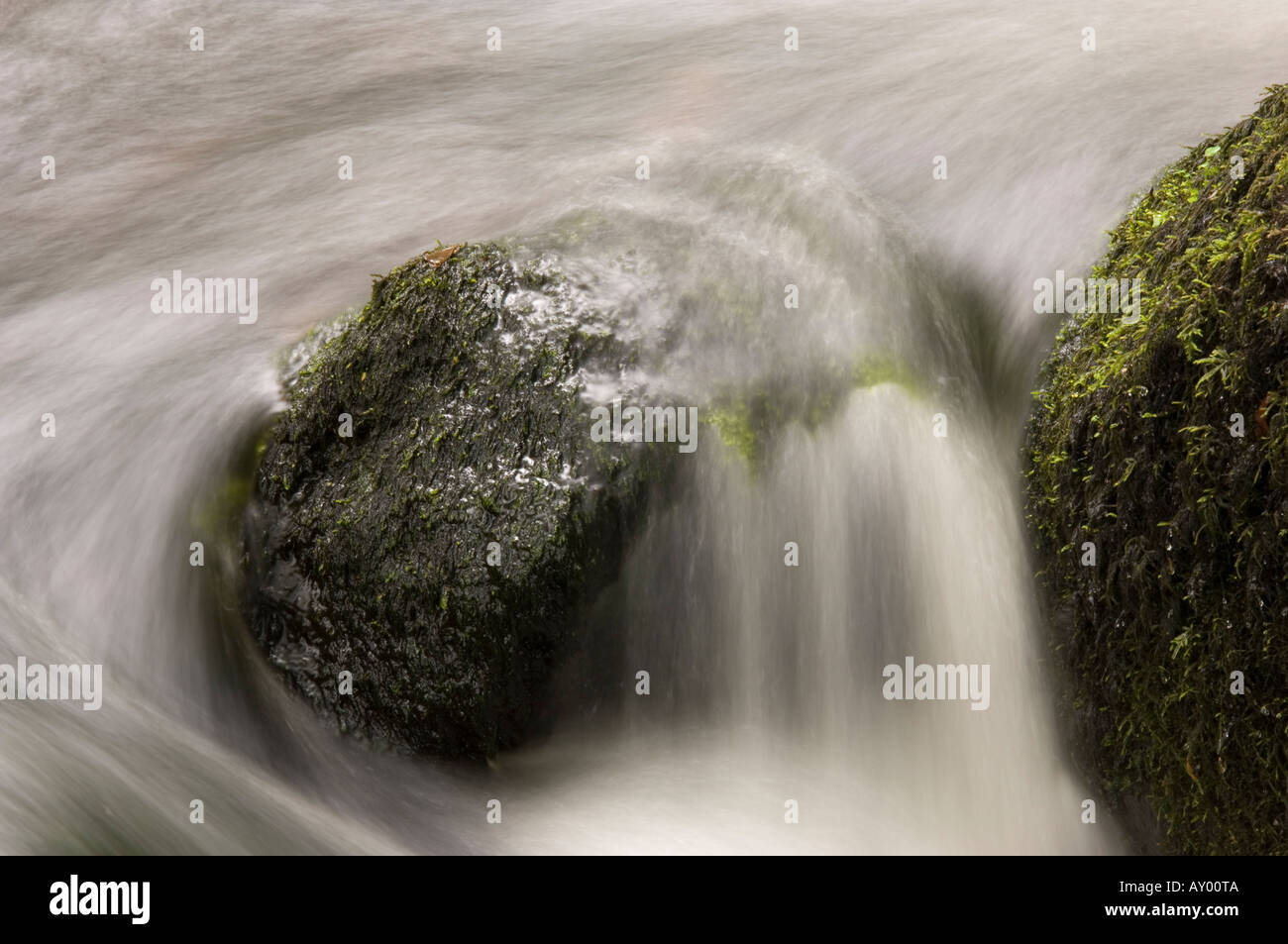 Water flowing around a boulder Becky Falls Dartmoor Devon England Stock ...
