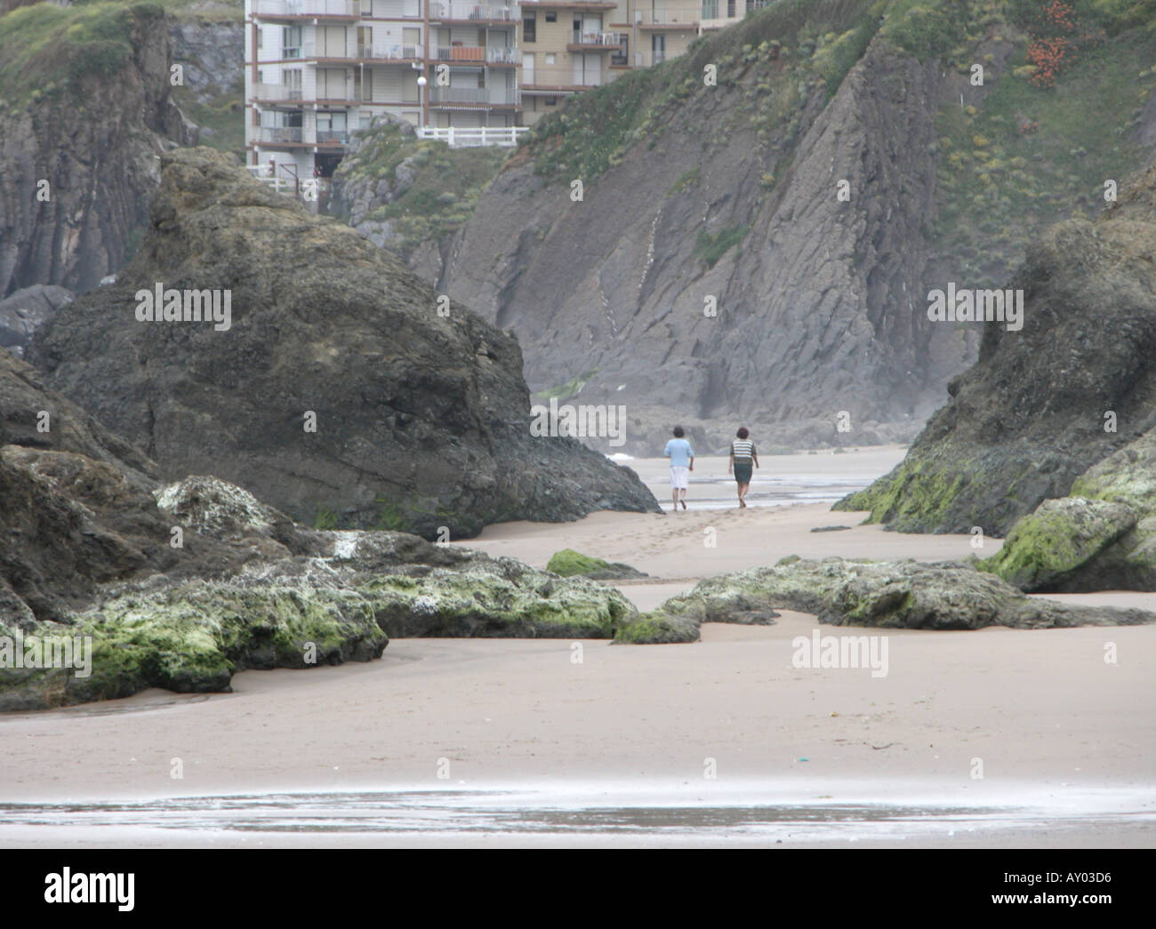 Two walkers at Bakio a beach resort in the Basque region of Spain Stock ...