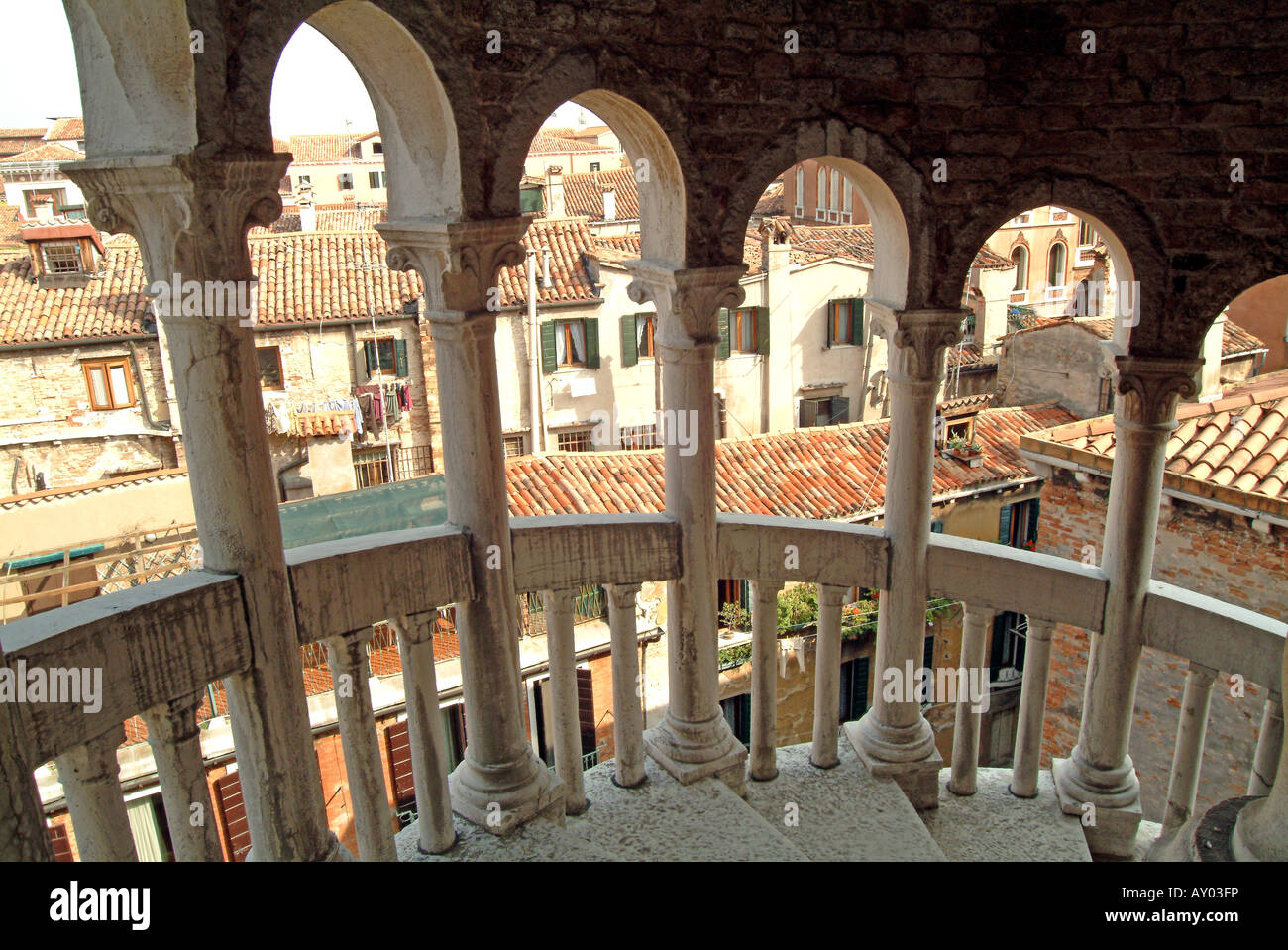 Red clay rooftops as seen through the stone carved spiral staircase at ...