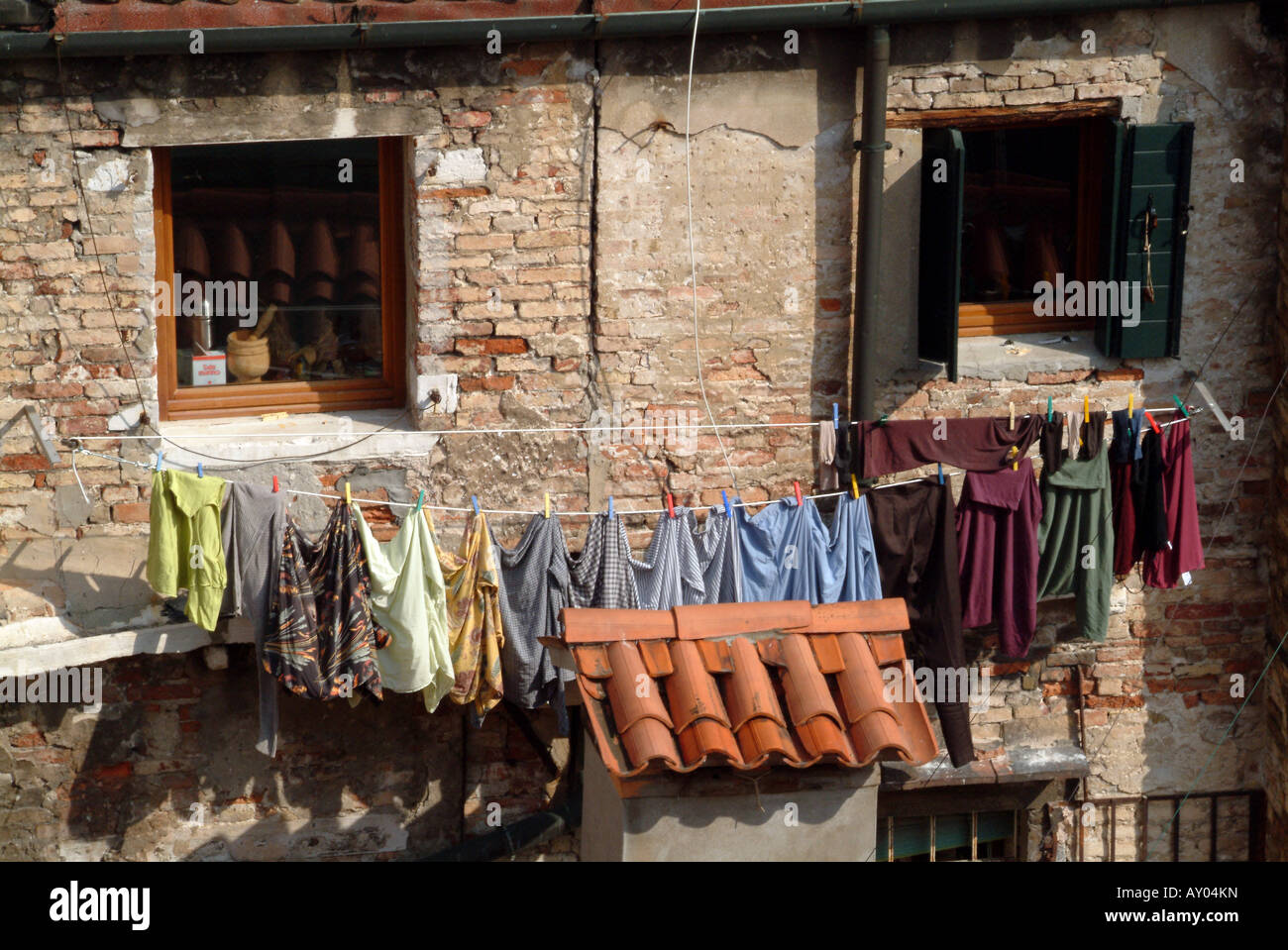 Washing line full of clothes hanging between two windows in old stone ...