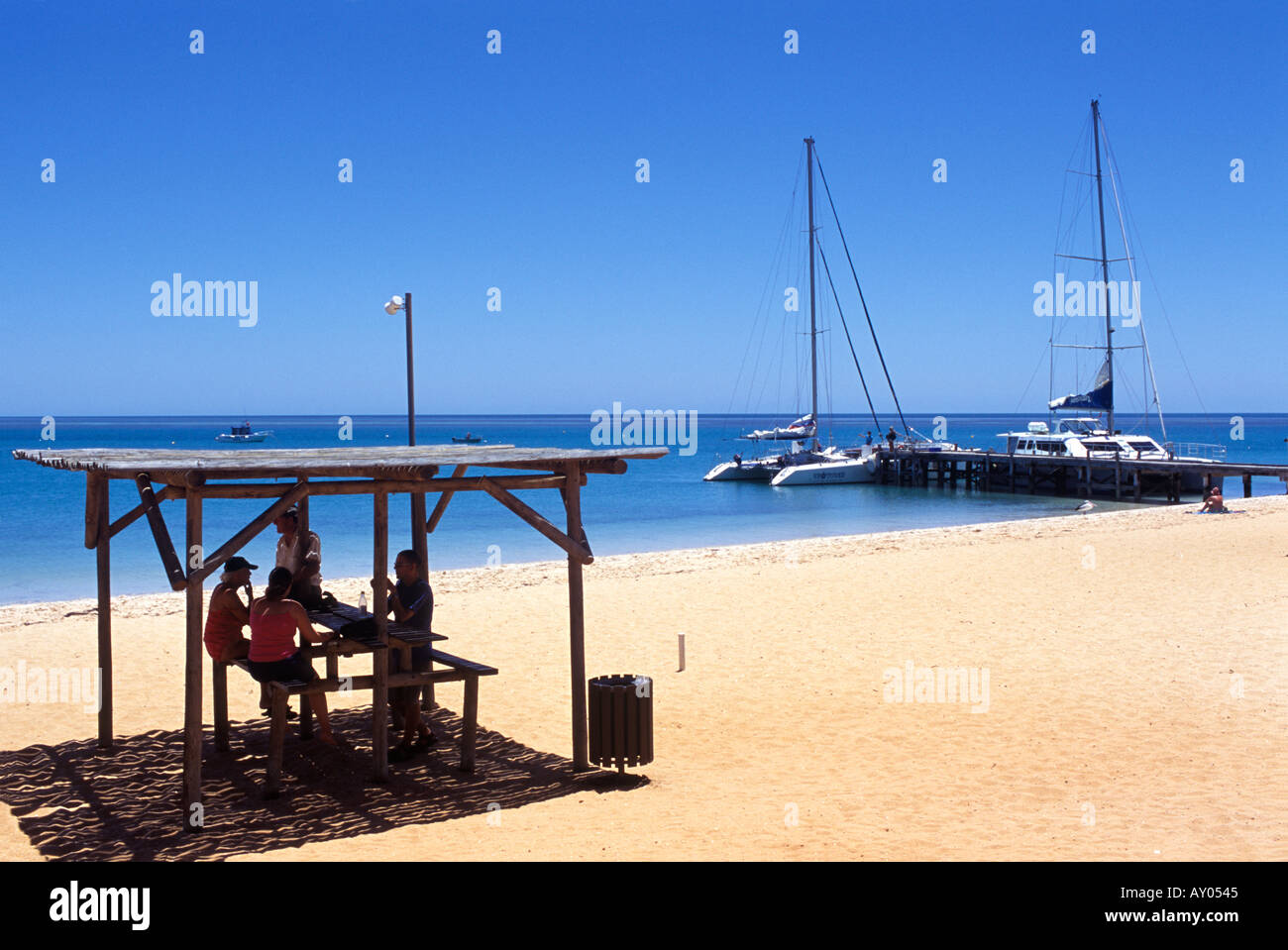 Idyllic beach setting with blue sky sea and boat Relaxing with a few ...