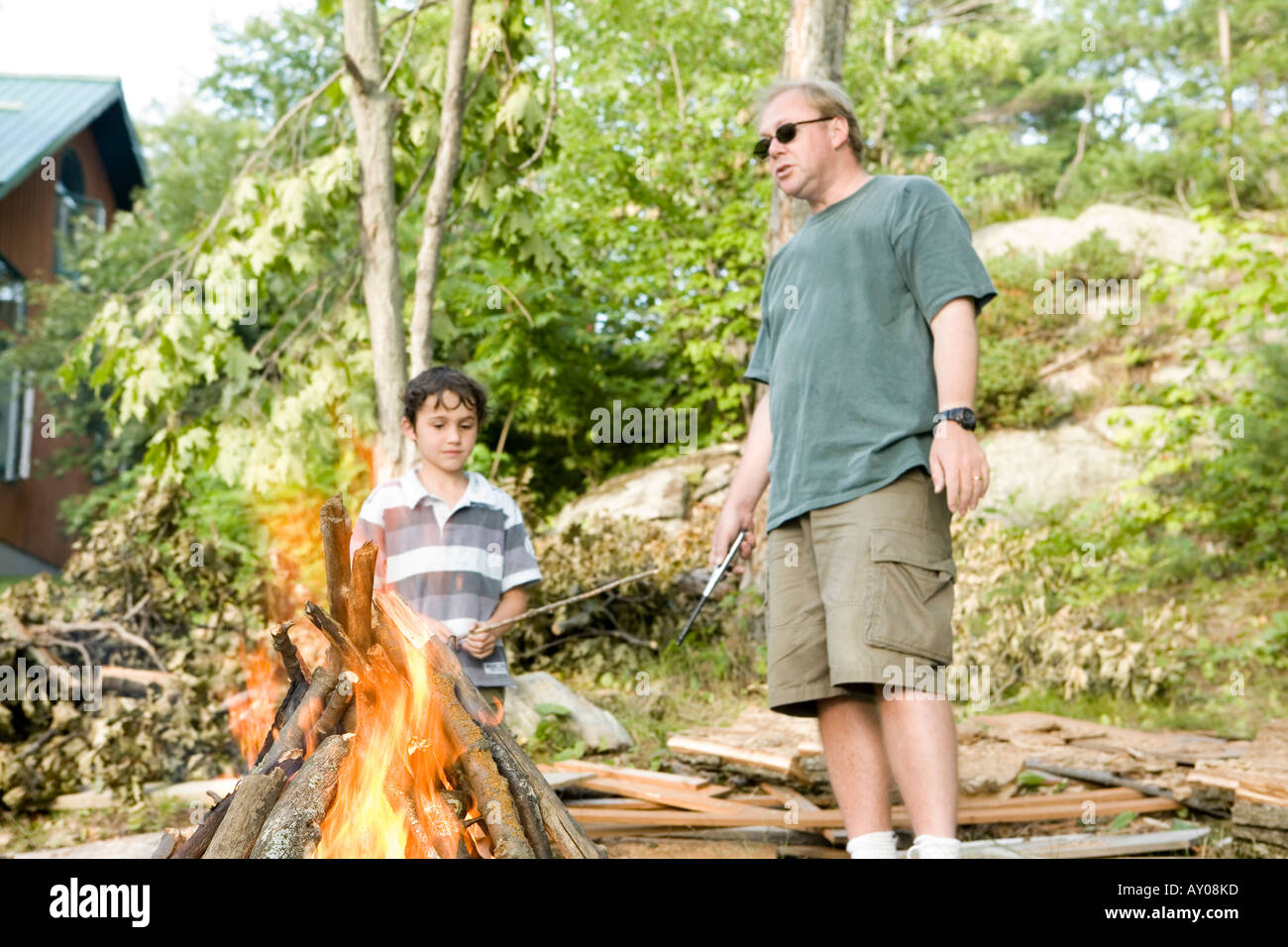 Boy and his Dad building a fire Stock Photo - Alamy