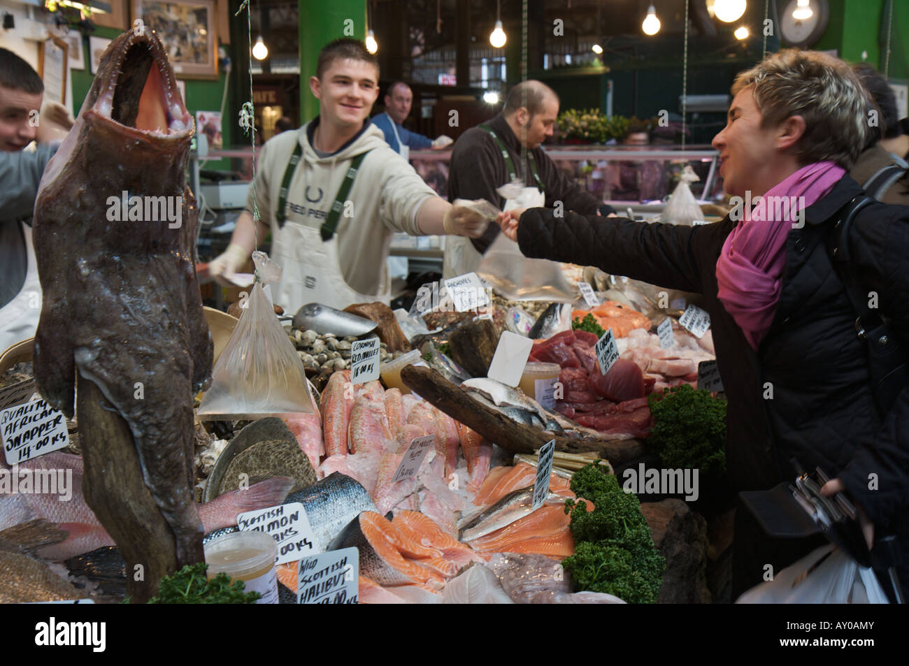 A customer makes a purchase at a fishmongers in London's Borough Market ...