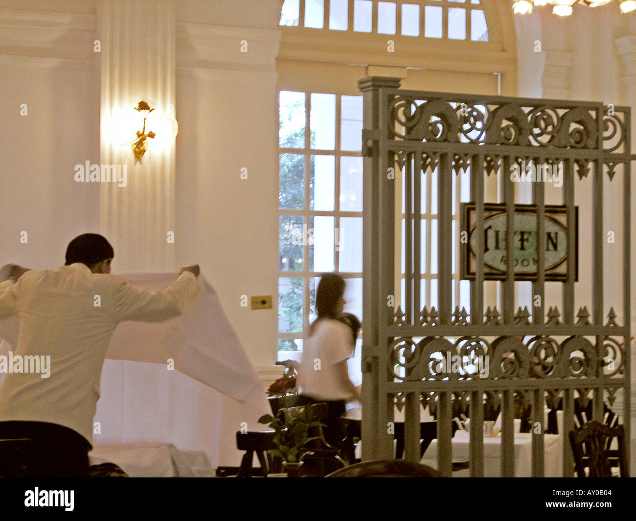 Waiter laying table at the Tiffin Room Raffles Hotel Singapore Stock ...