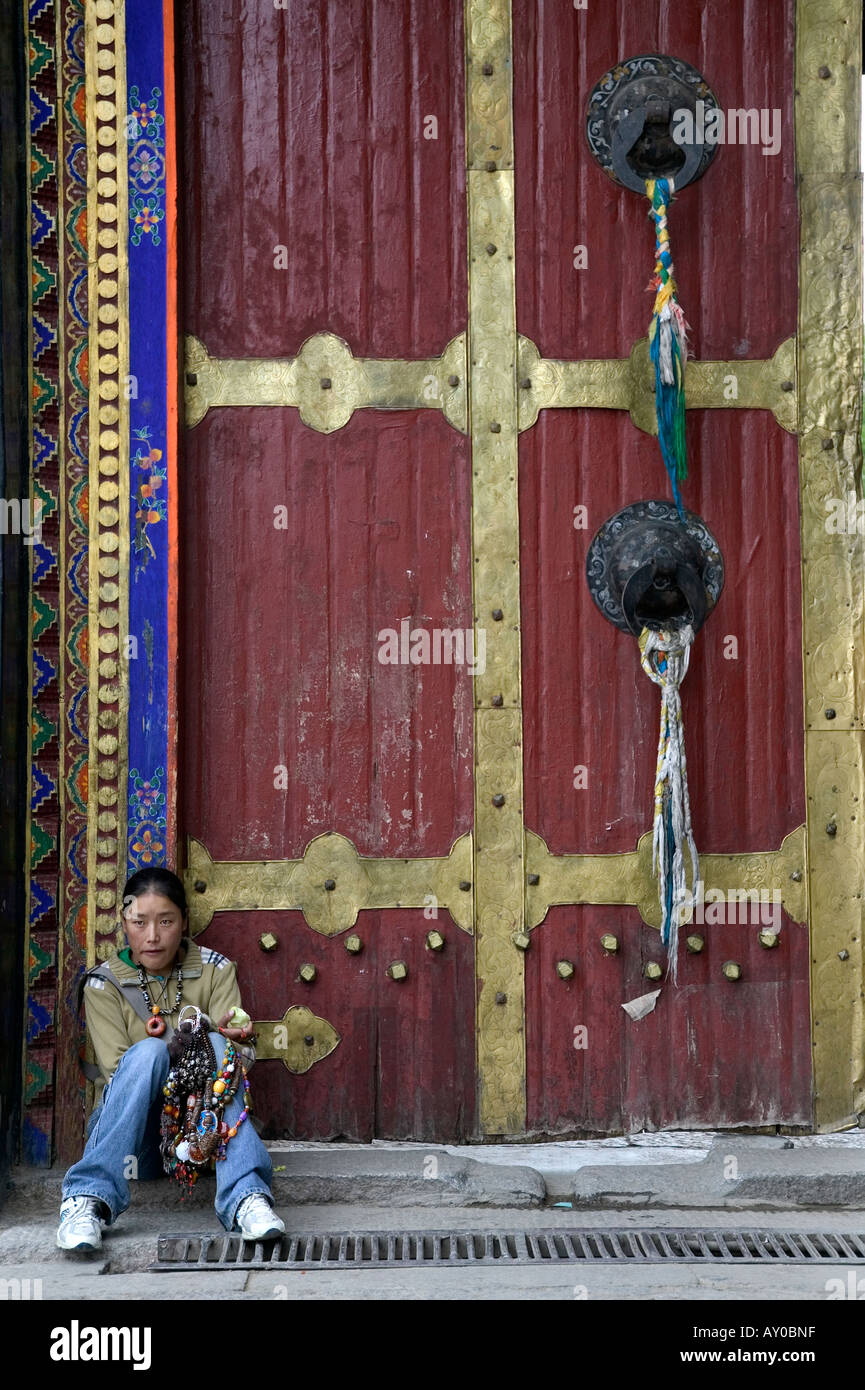 Young girl sits at foot of door to Potala Palace, Lhasa, Tibet ...