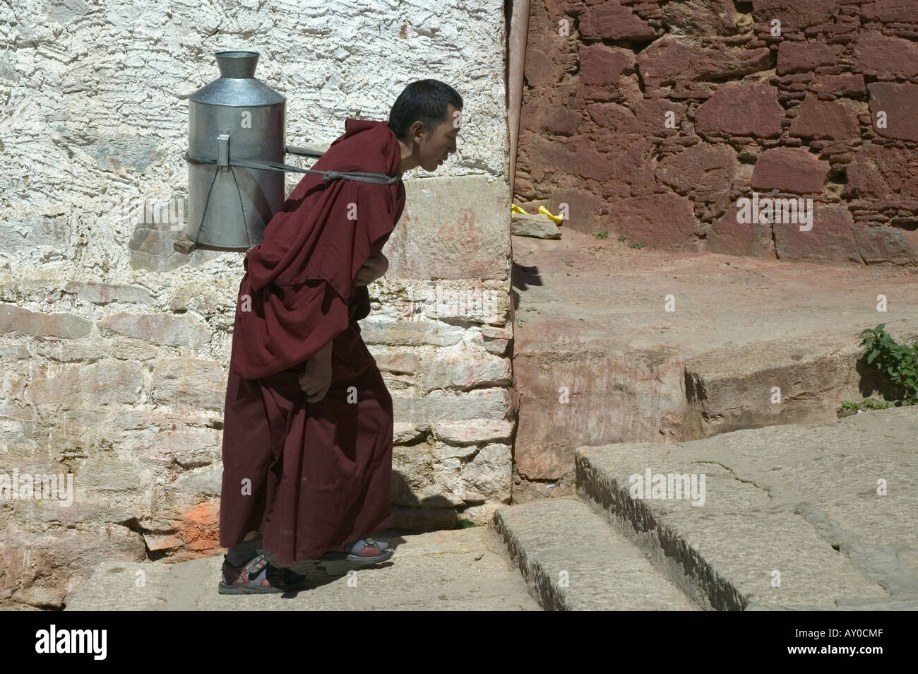 Tibetan monk carries water urn, Ganden Monastery, Tibet Autonomous ...