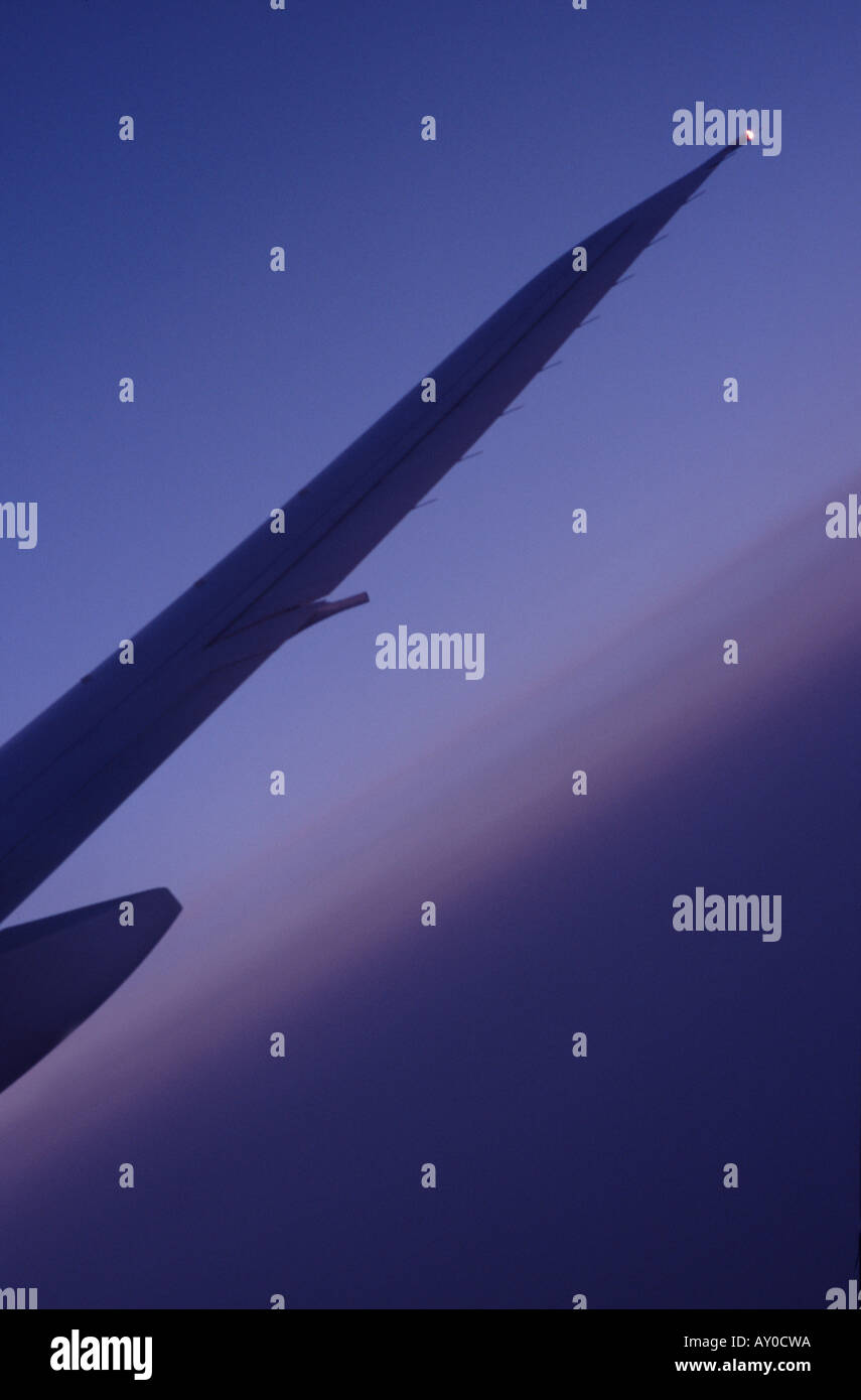 airplane wing shot at a graphic angle against a dusk sky at night Stock ...