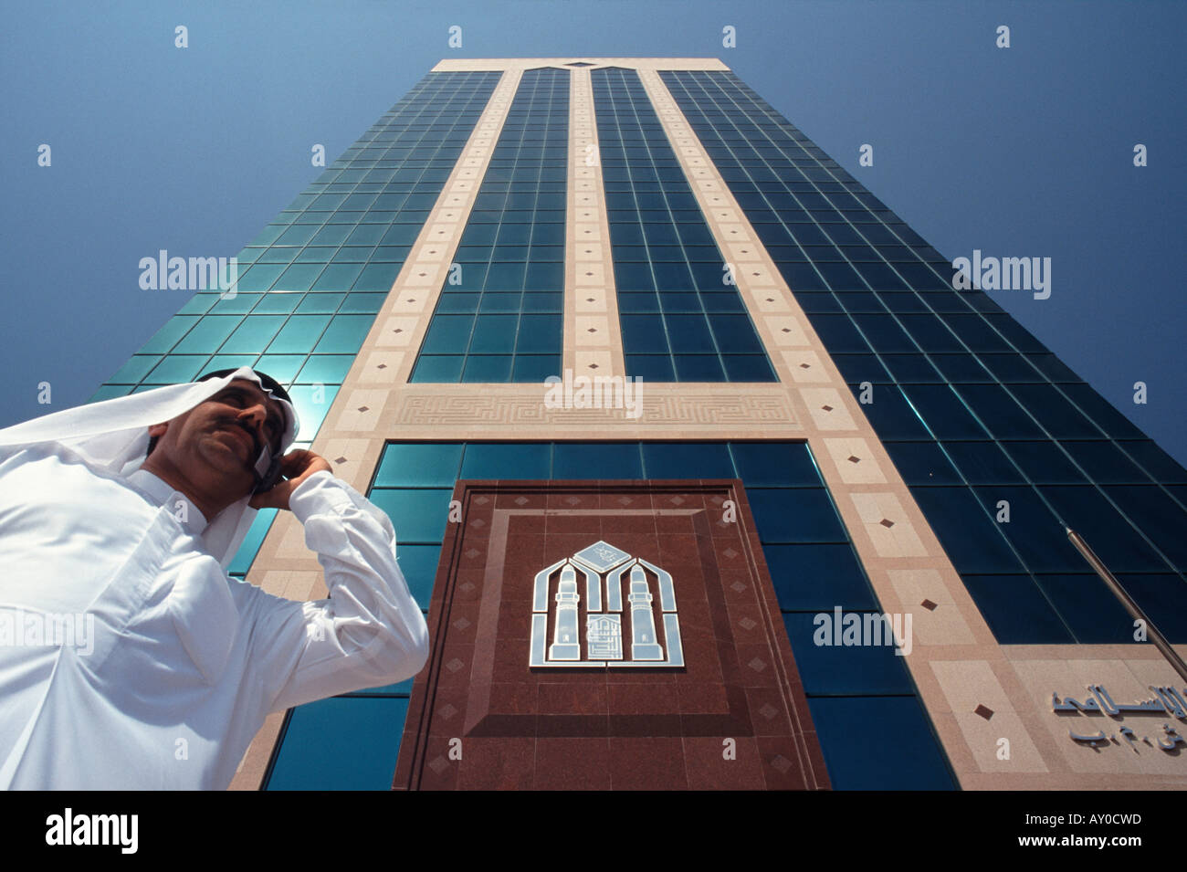 bahrainian businessman on his mobile phone infront of bank entrance in ...