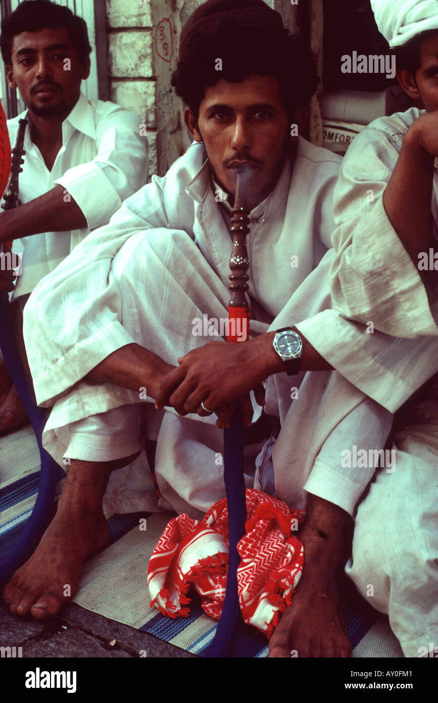 young saudi arabian man smoking arabic hubble bubble hookah pipe in the ...