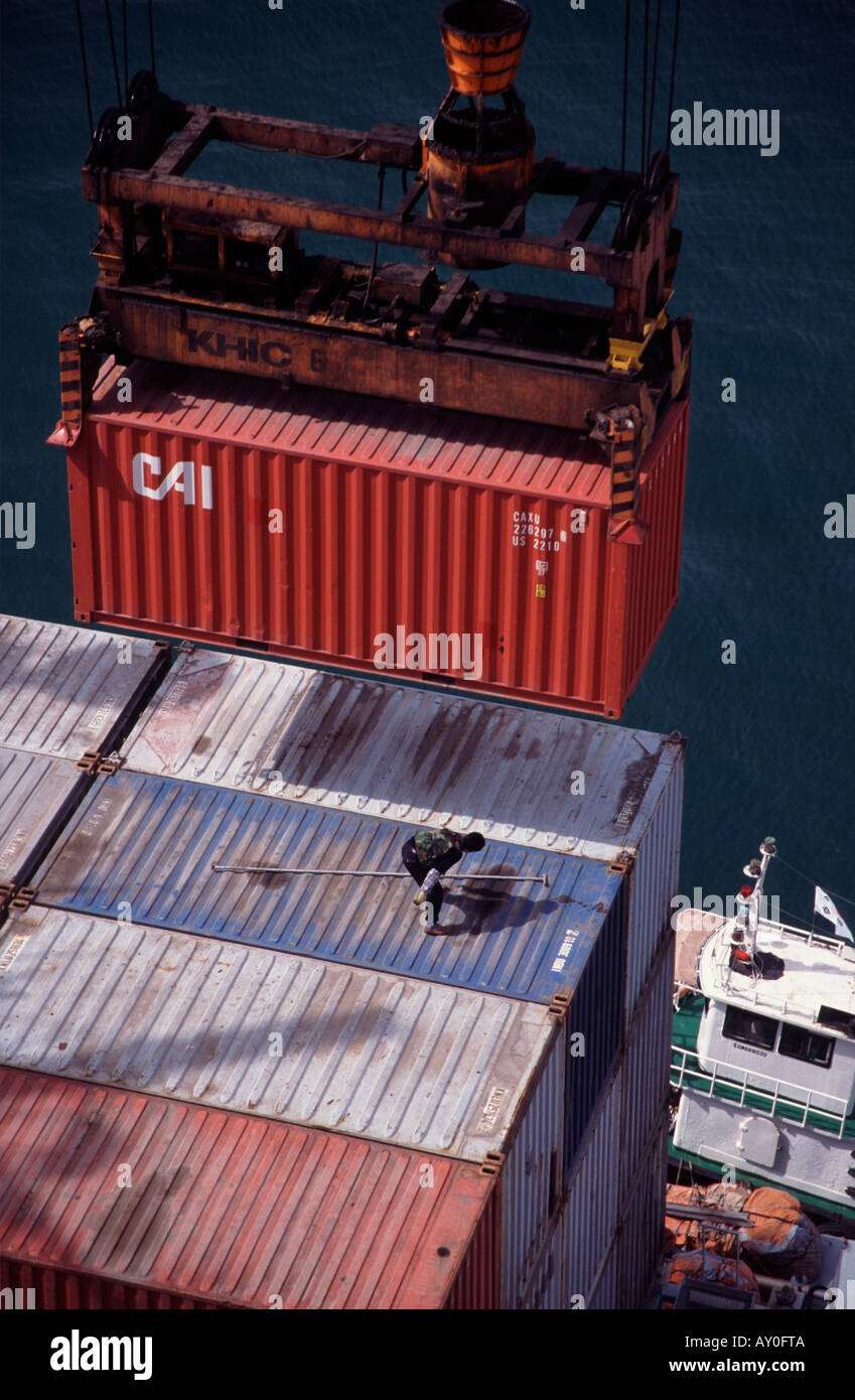 Containership worker directing loading of containers onto ship pusan ...