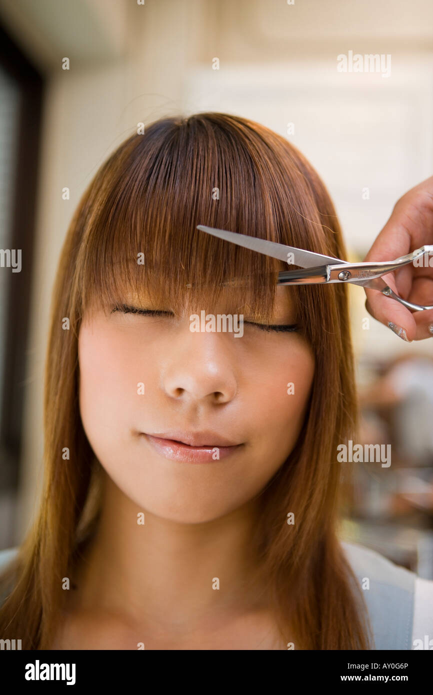 Young woman getting bangs cut Stock Photo - Alamy