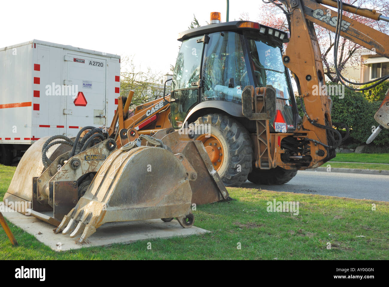 Backhoe Buckets alongside it's Backhoe Stock Photo - Alamy