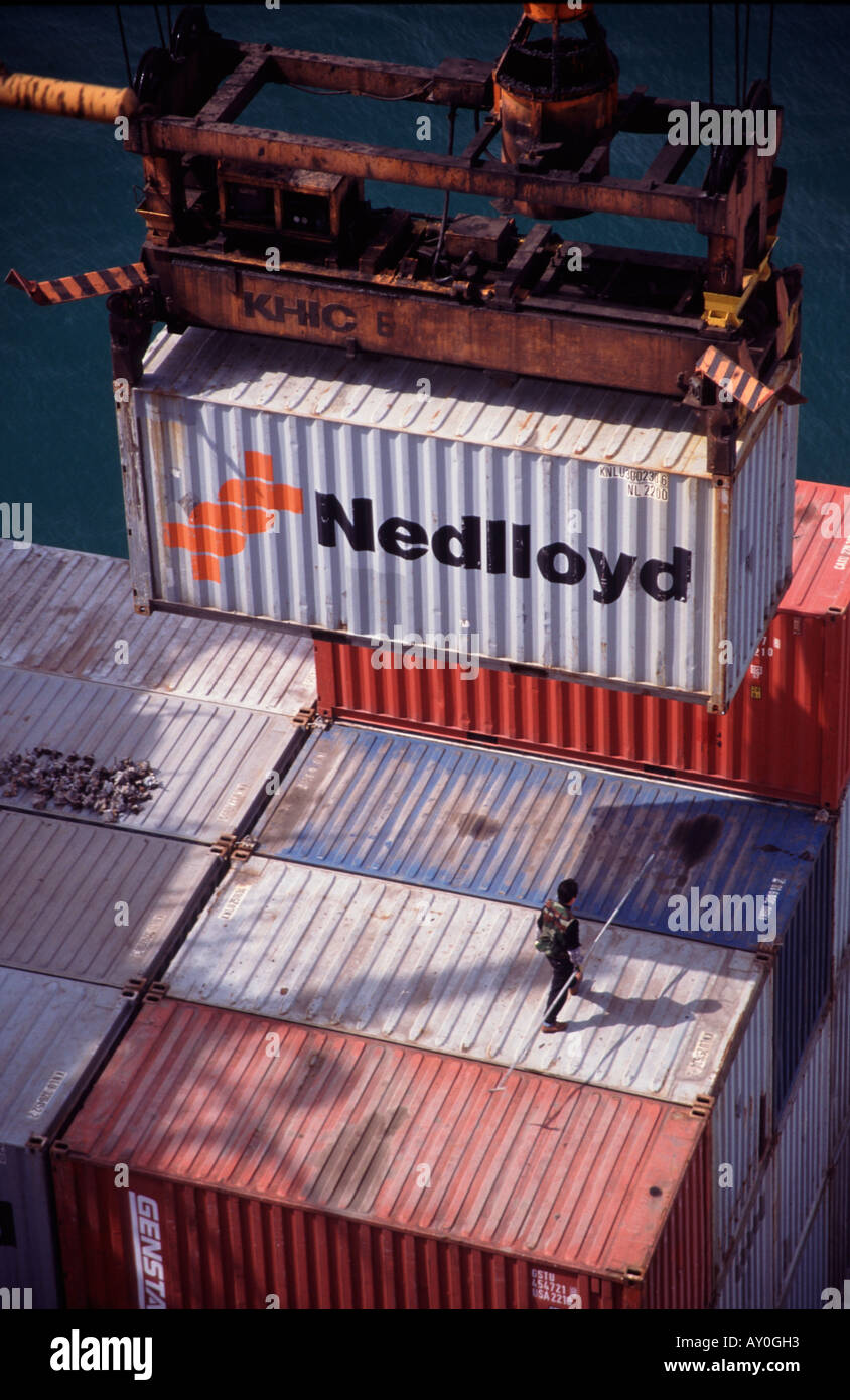 Containership worker directing loading of containers onto ship pusan ...