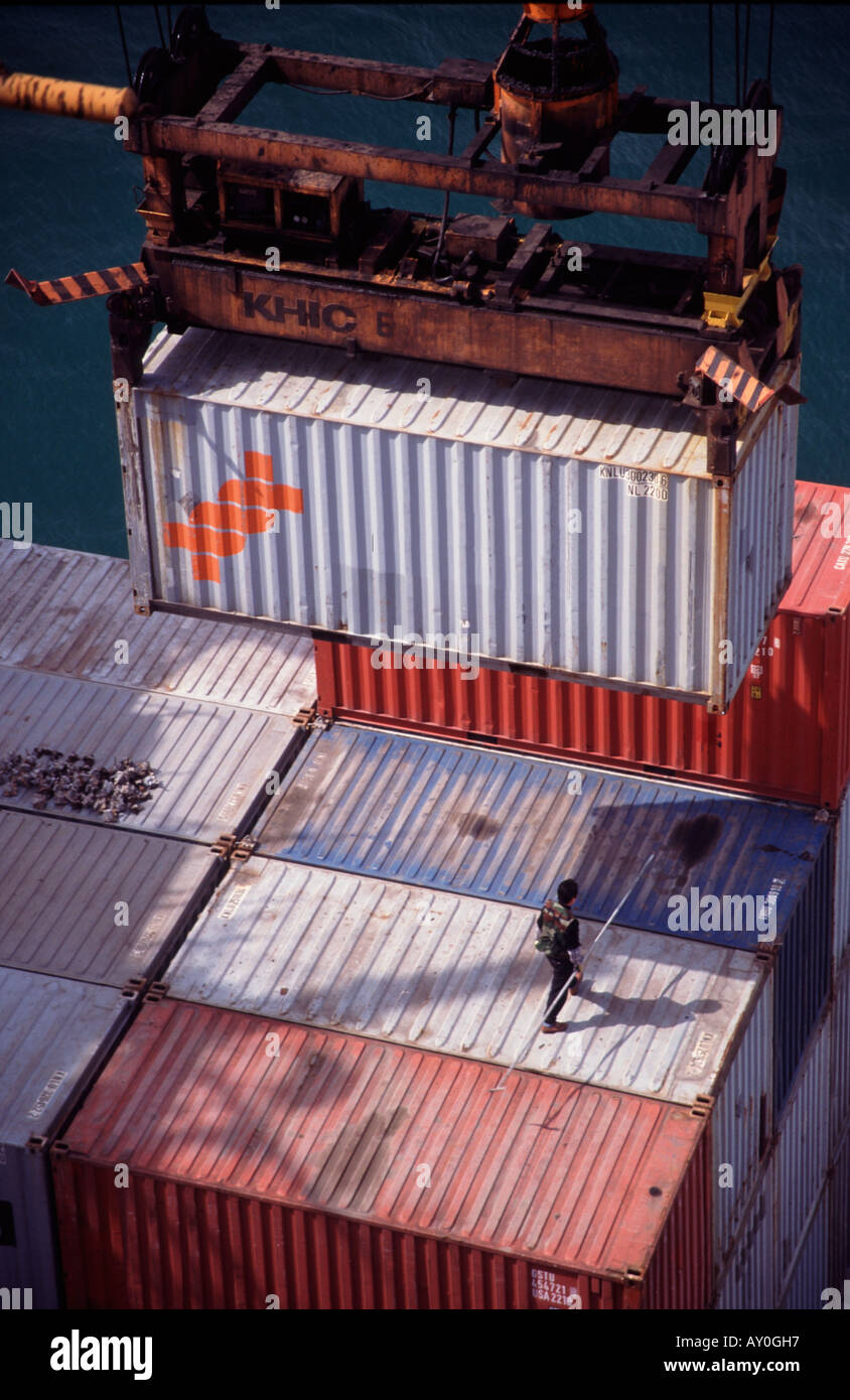 Containership worker directing loading of containers onto ship pusan ...