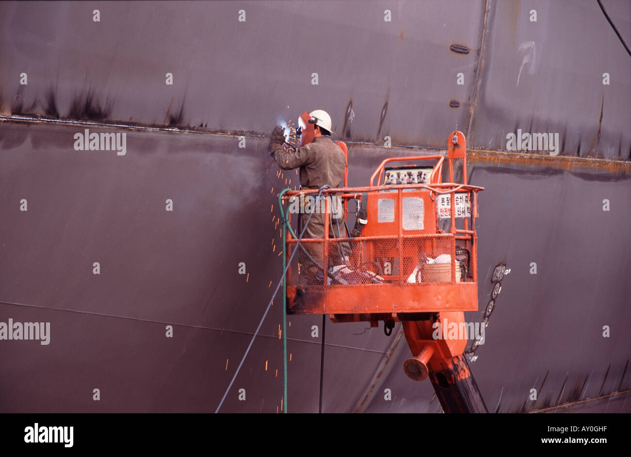 daewoo shipyard worker welding hull section of new containership in dry ...