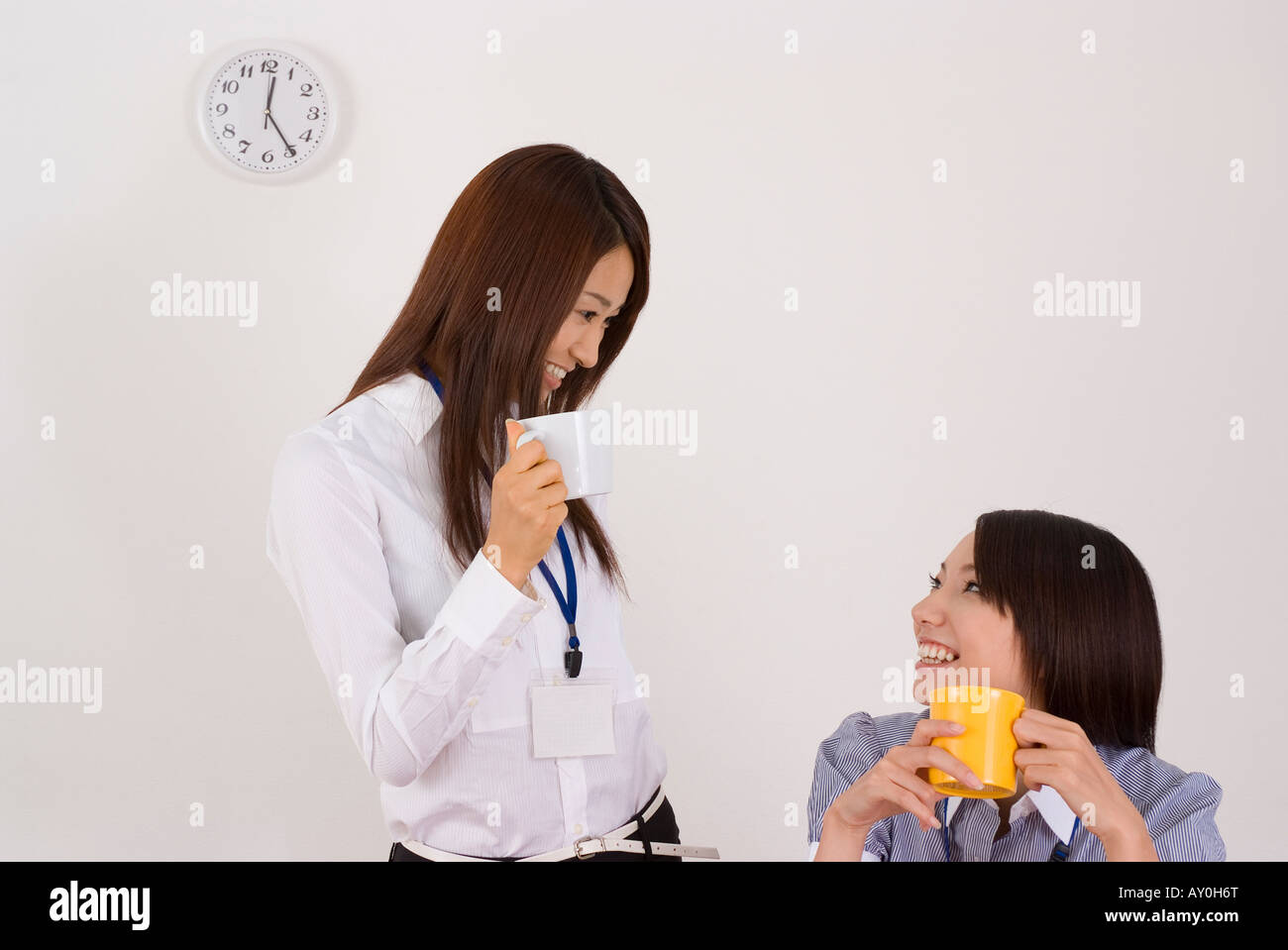 Two young women talking in office Stock Photo - Alamy