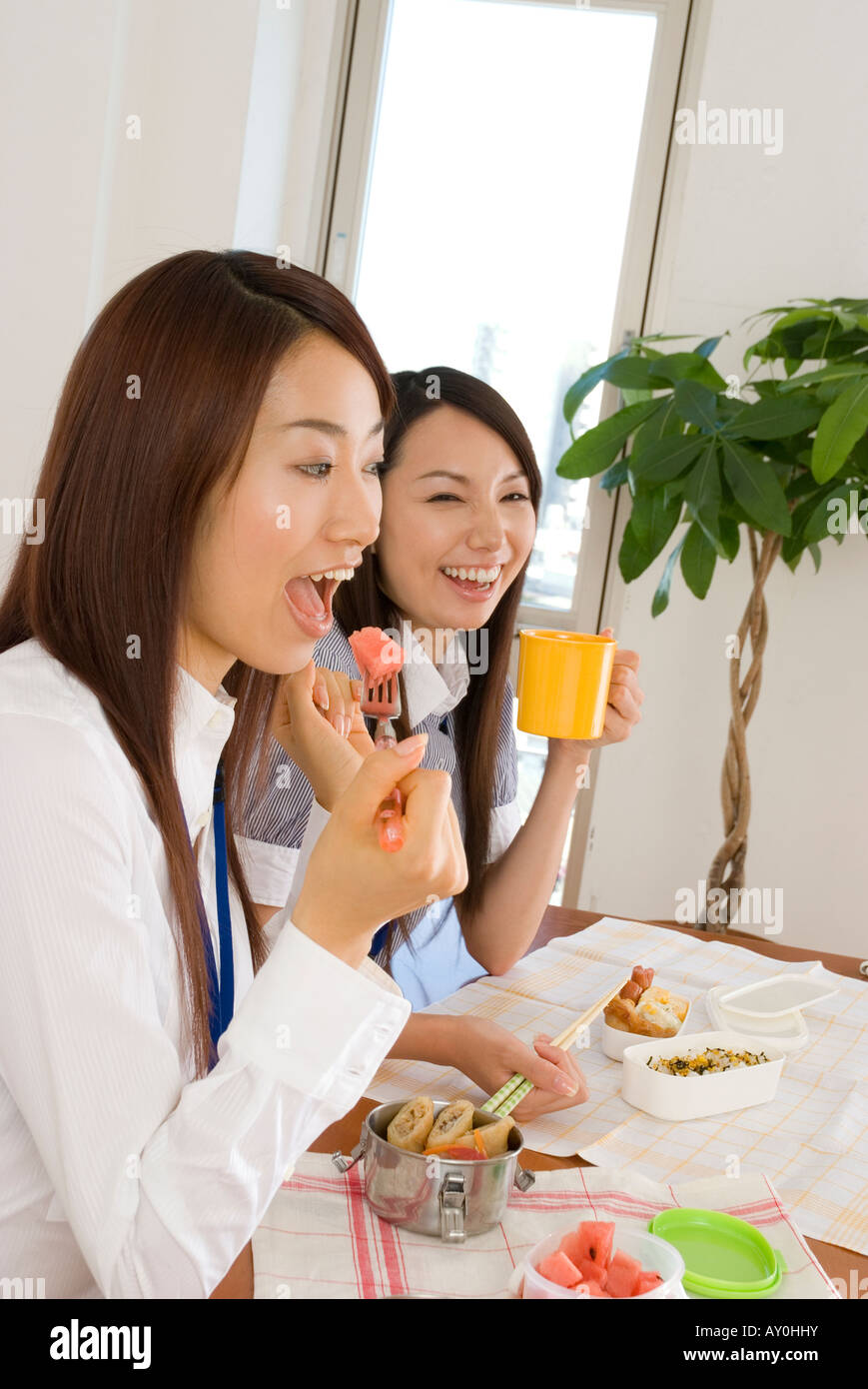 Two young women eating lunch Stock Photo - Alamy