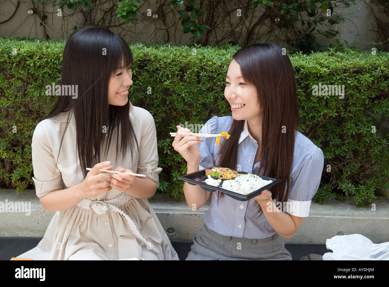 Two young women eating lunch Stock Photo - Alamy