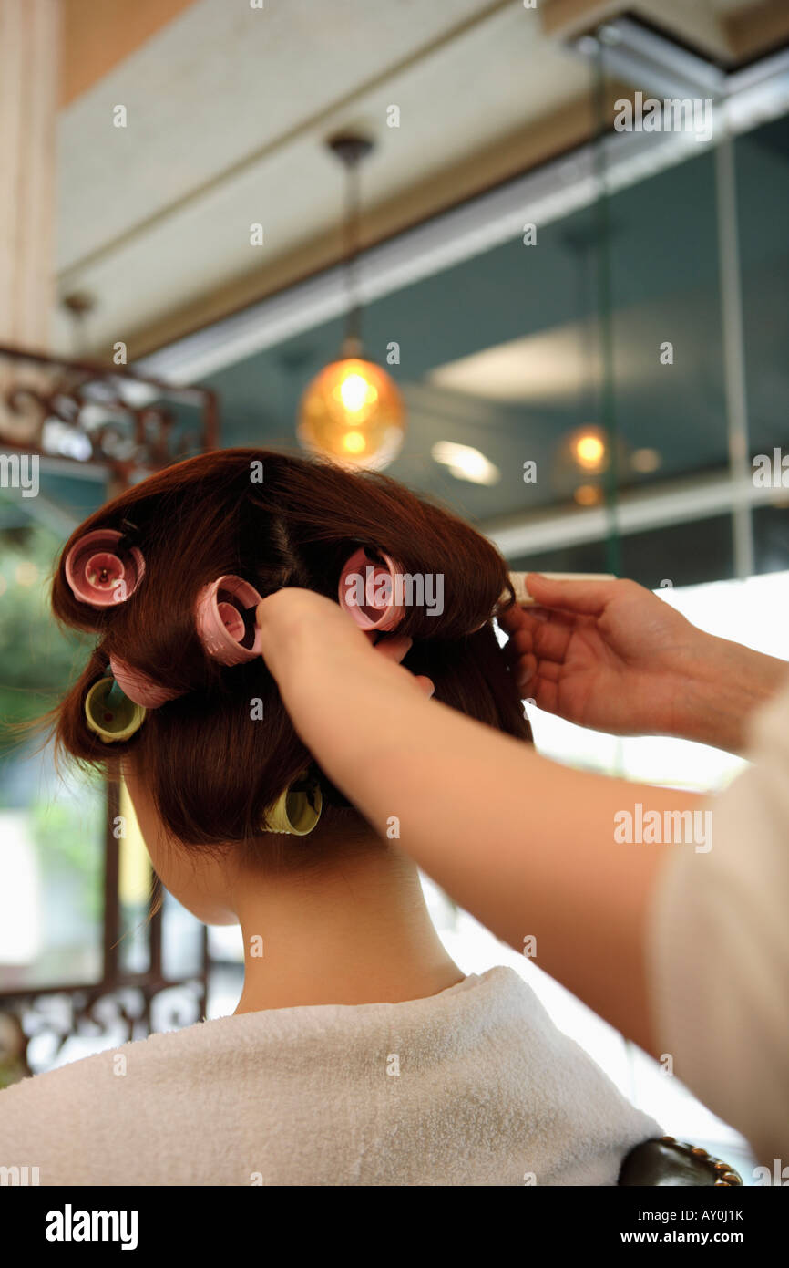 Hairdresser putting curlers in customer's hair Stock Photo - Alamy