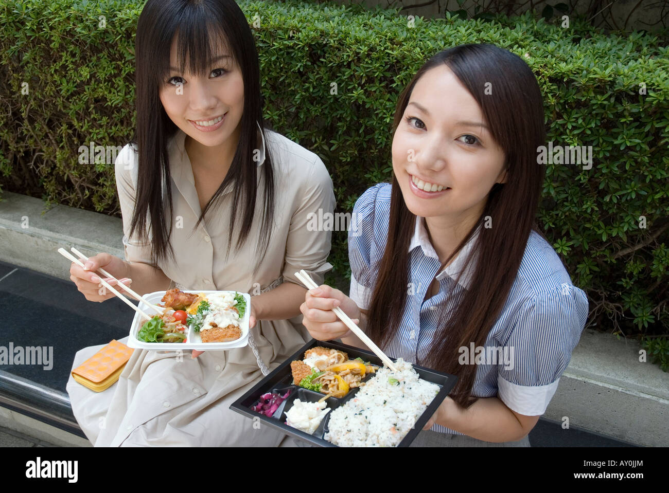 Two young women eating lunch Stock Photo - Alamy