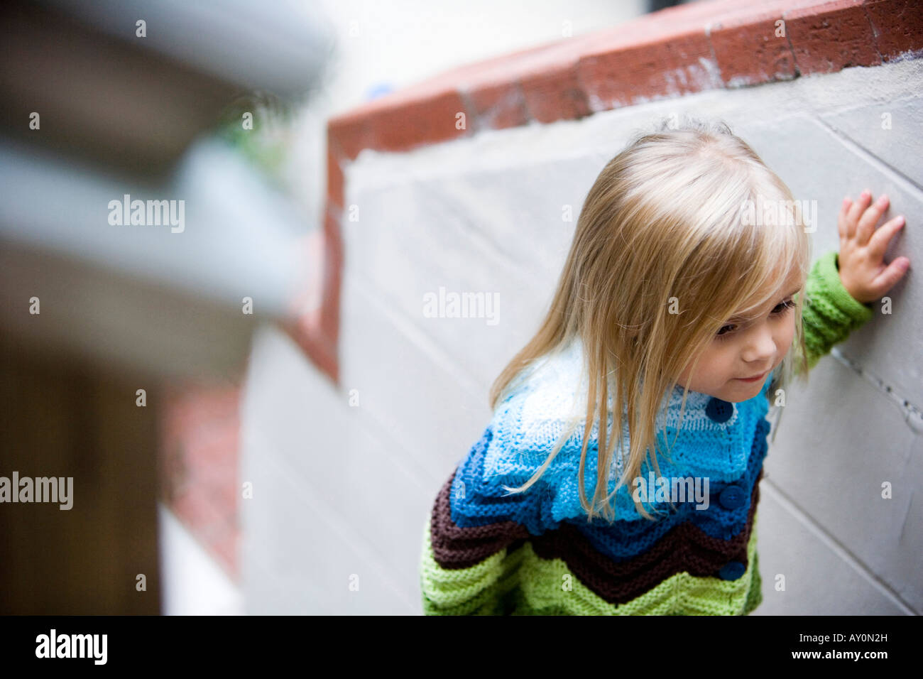 Girl standing by wall Stock Photo - Alamy