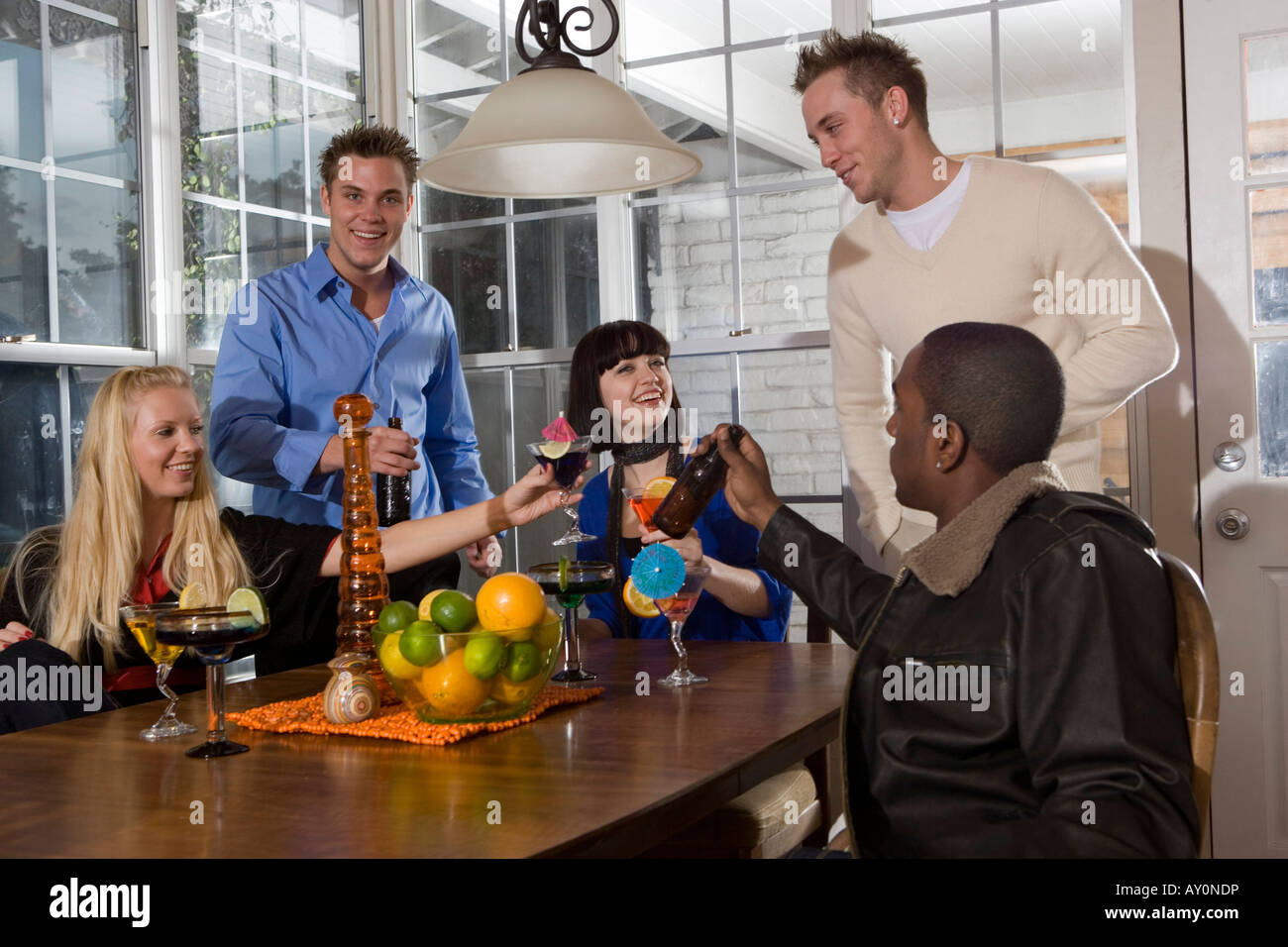 Friends enjoying their drinks in dining room Stock Photo - Alamy