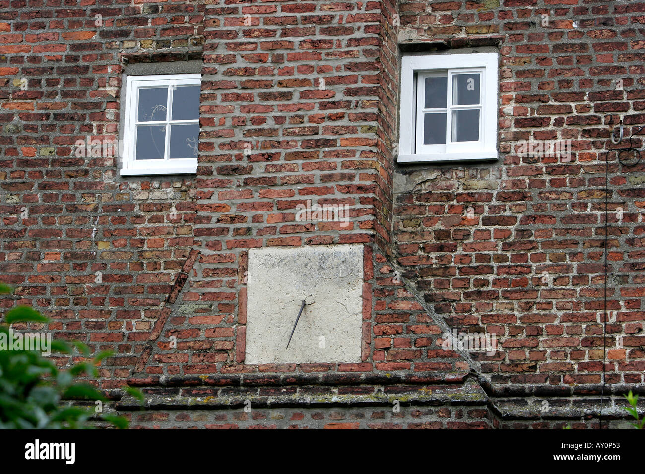 Sundial between two small windows of red brick house in Cambridgeshire ...