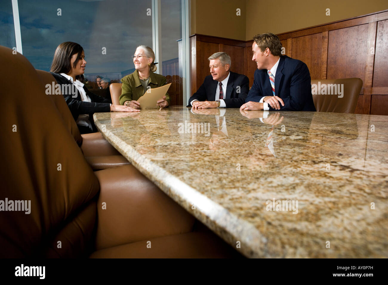 Business people sitting by conference table and discussing in an office ...