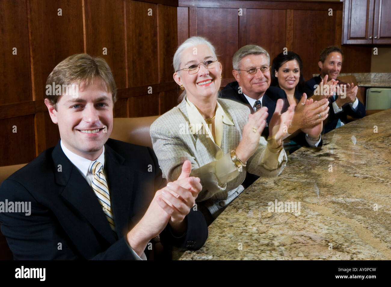 Portrait of cheerful business people sitting by conference table and ...