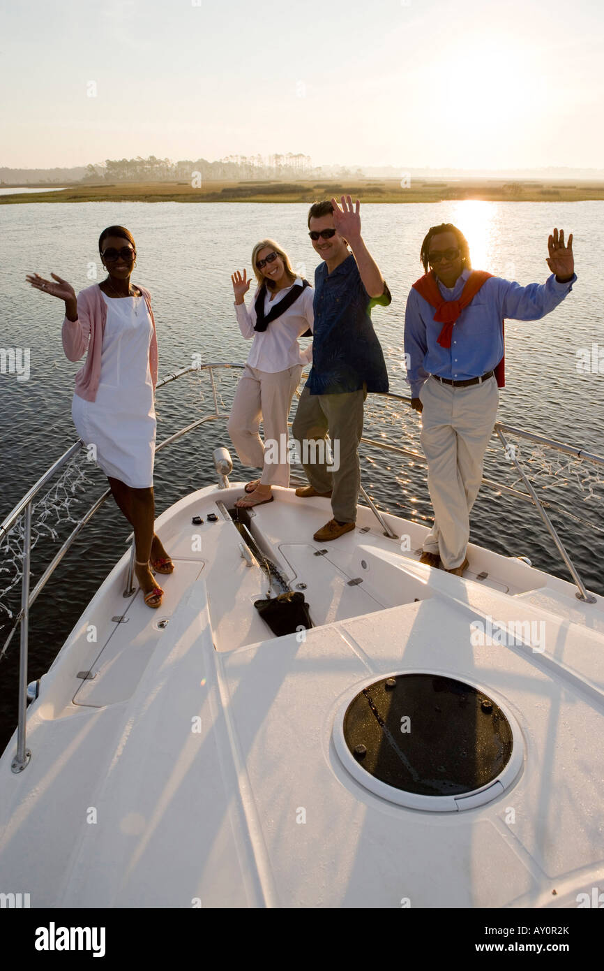Portrait of smiling friends waving on the deck of a boat Stock Photo ...