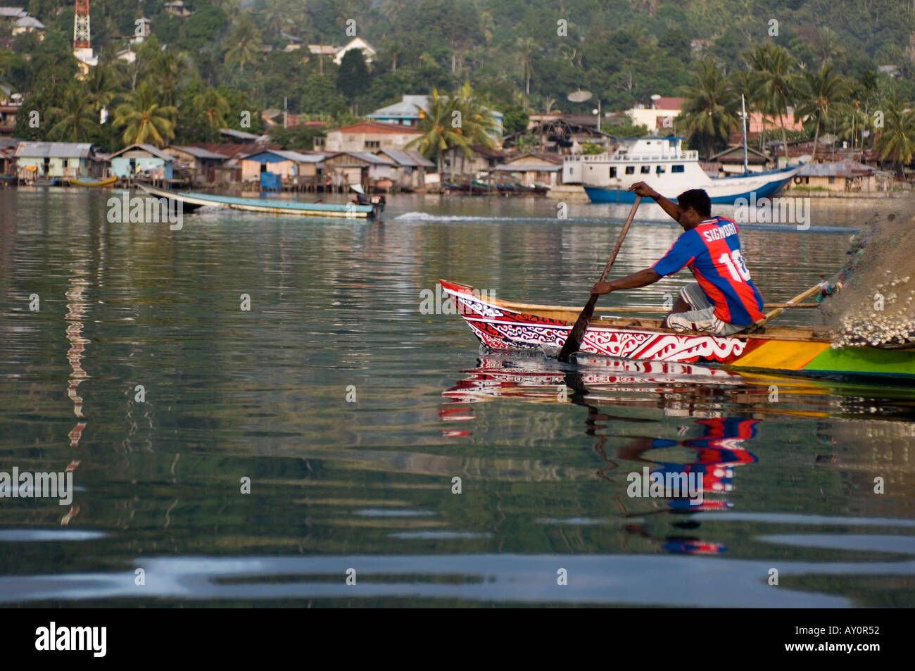 Brightly painted fishing canoe in a harbour, Manokwari, West Papua ...