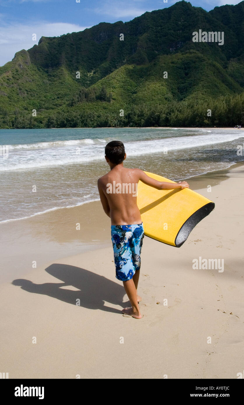 Boy with bodyboard and his shadow at Kahana Bay, Hawaii Stock Photo - Alamy