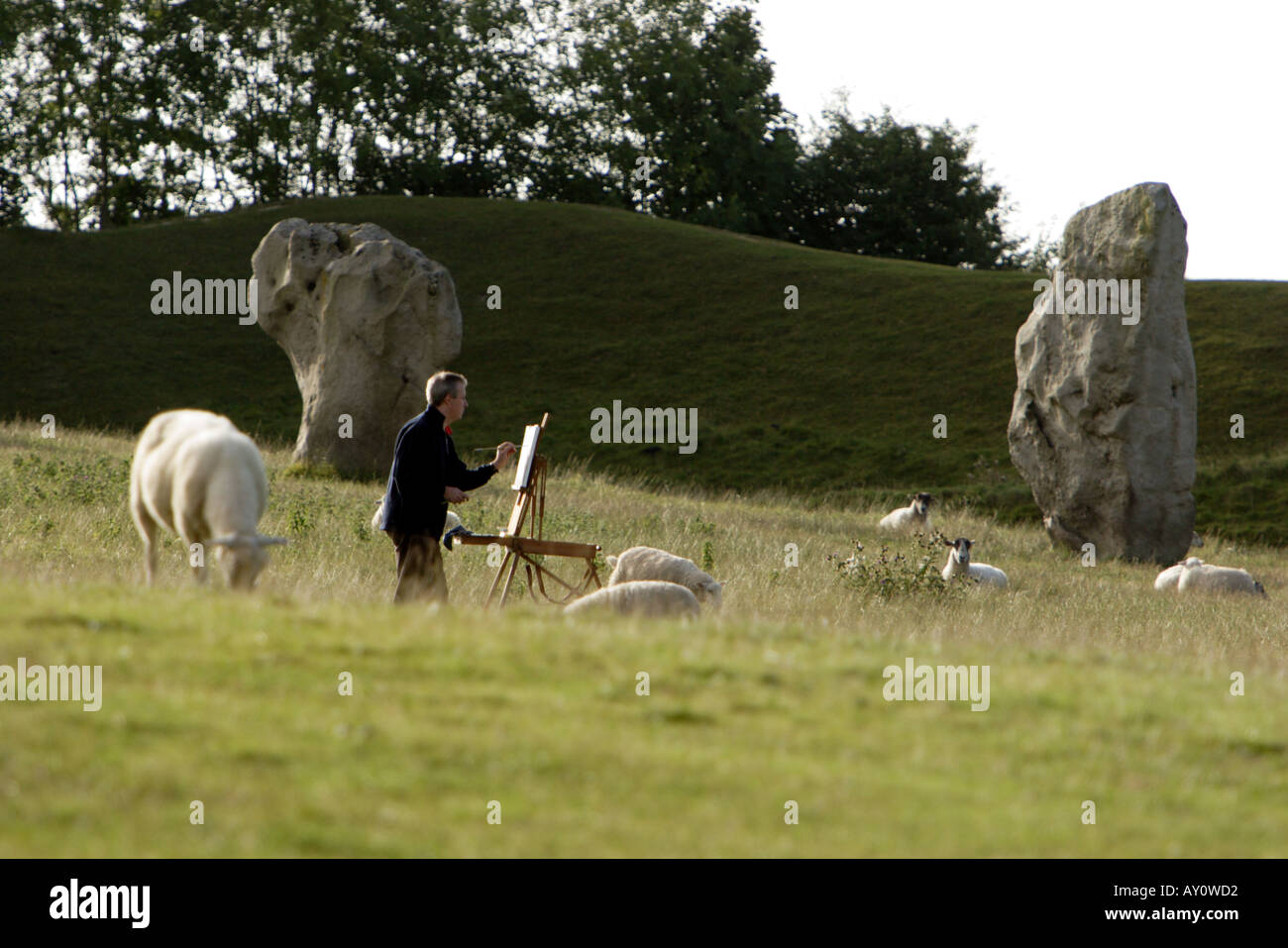An artist painting within the ancient stone circle at Avebury Wiltshire ...