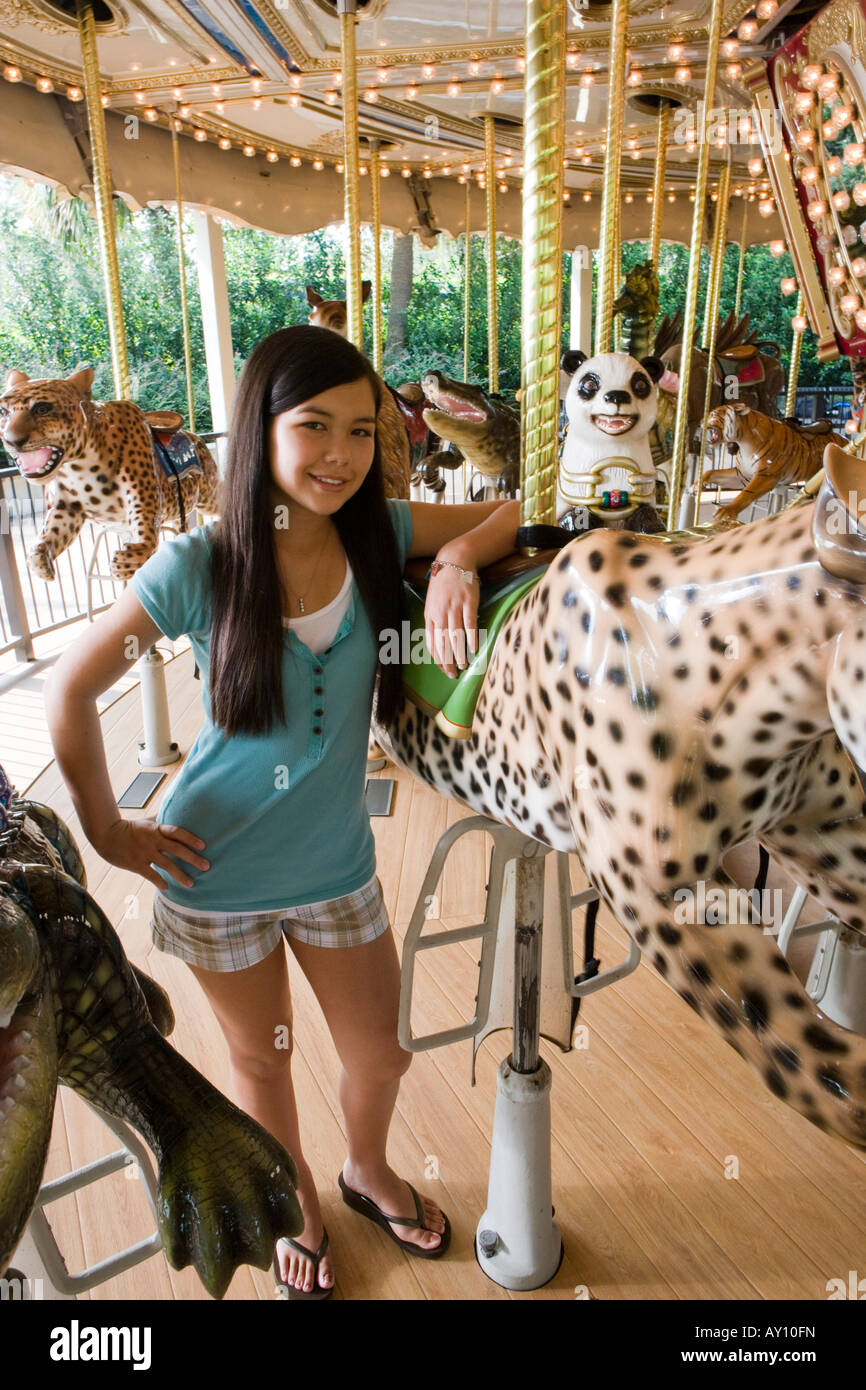 Portrait of a cheerful girl standing in a carousel by a carousel ...